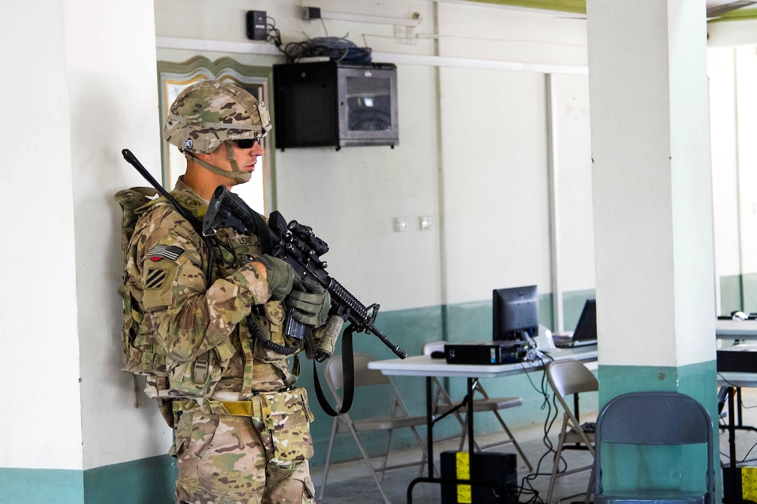 U.S. Army Sgt. Peter Leahy provides security during a meeting at the ...