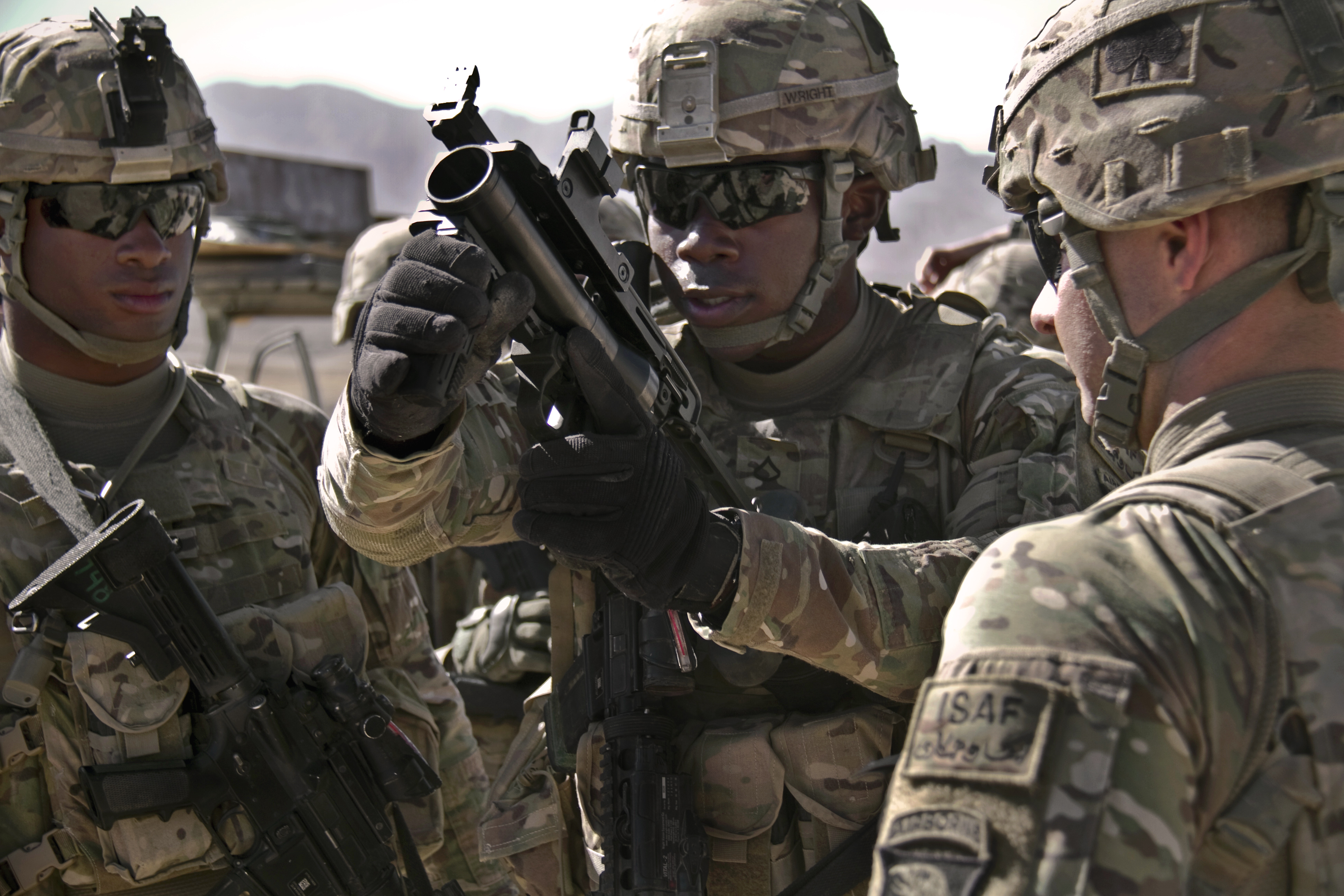 U.S. Army Pfc. Rohan Wright, center, prepares to fire an M203 grenade ...