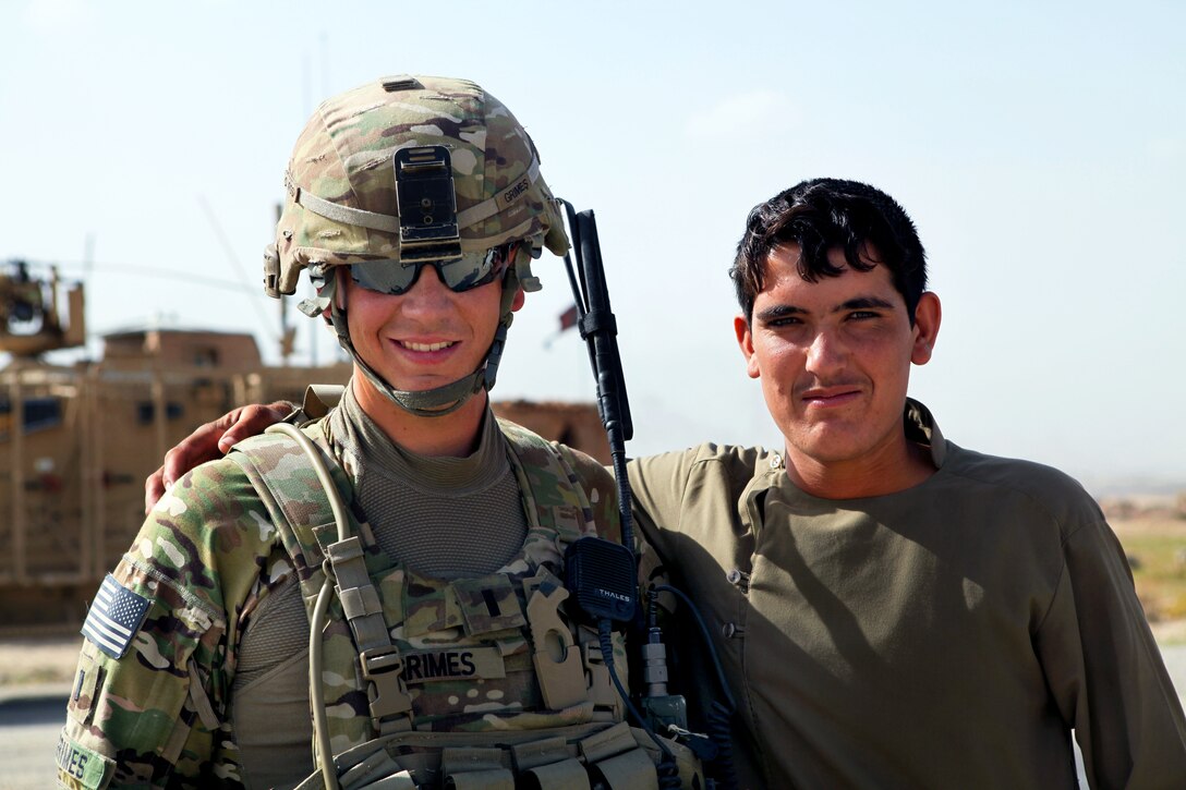 U.S. Army 1st Lt. Stoney Grimes, left, poses for a photo with an Afghan ...