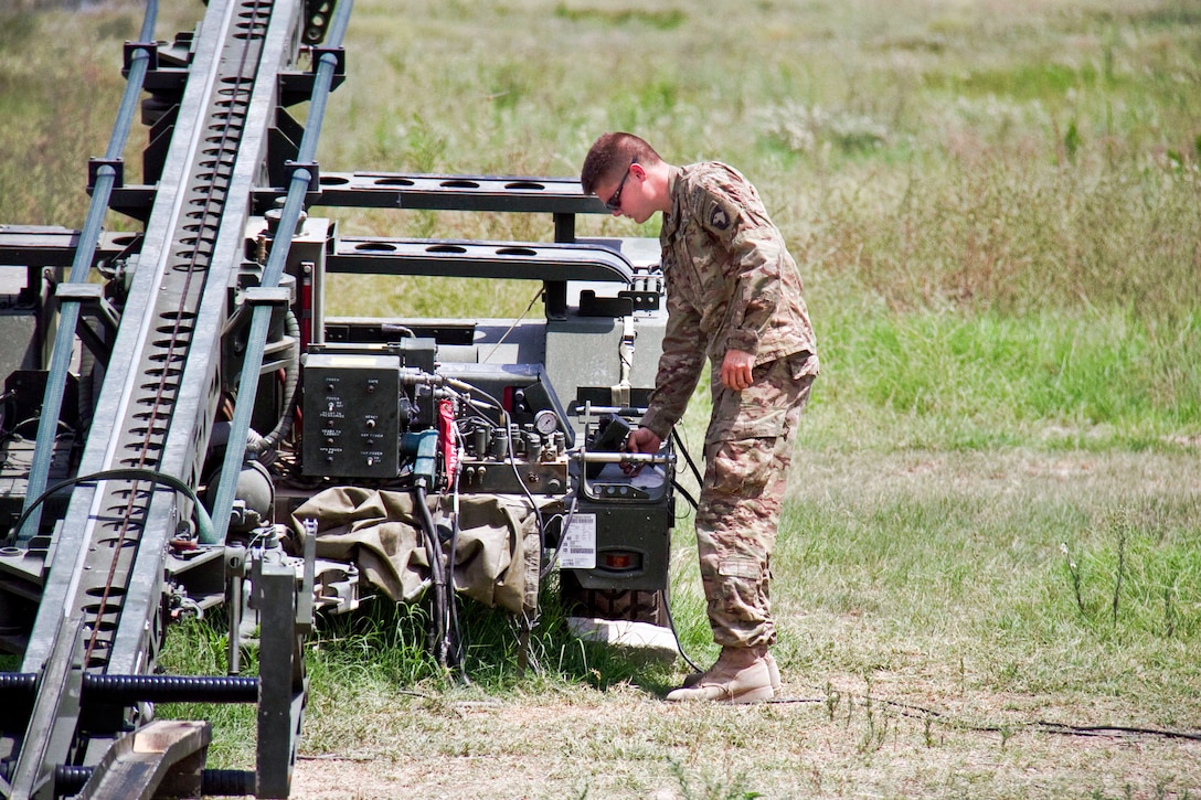 U.S. Army Spc. Nathan C. Phillips prepares the pneumatic launcher for ...