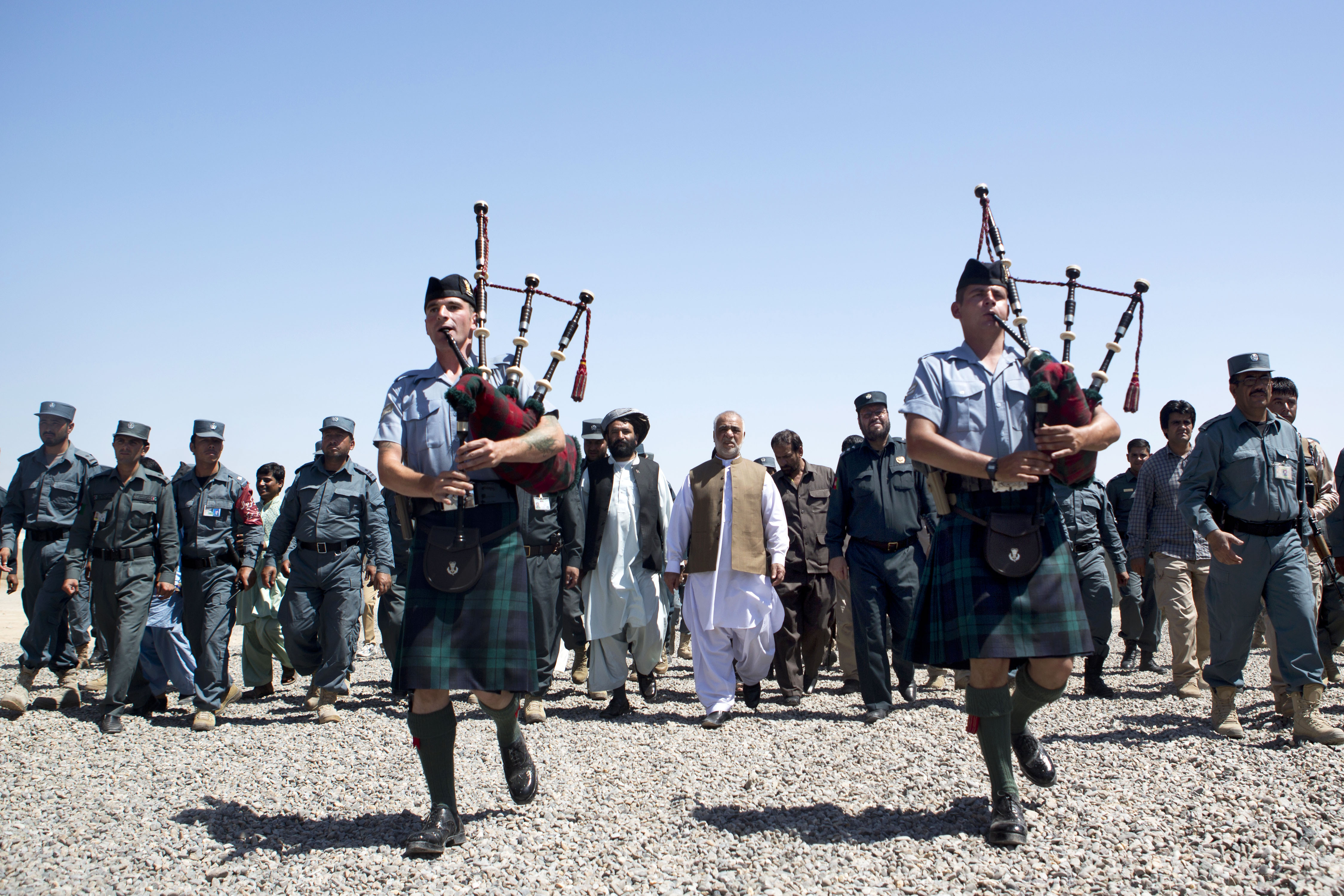 Bagpipers lead a procession of coalition and Afghan security forces ...
