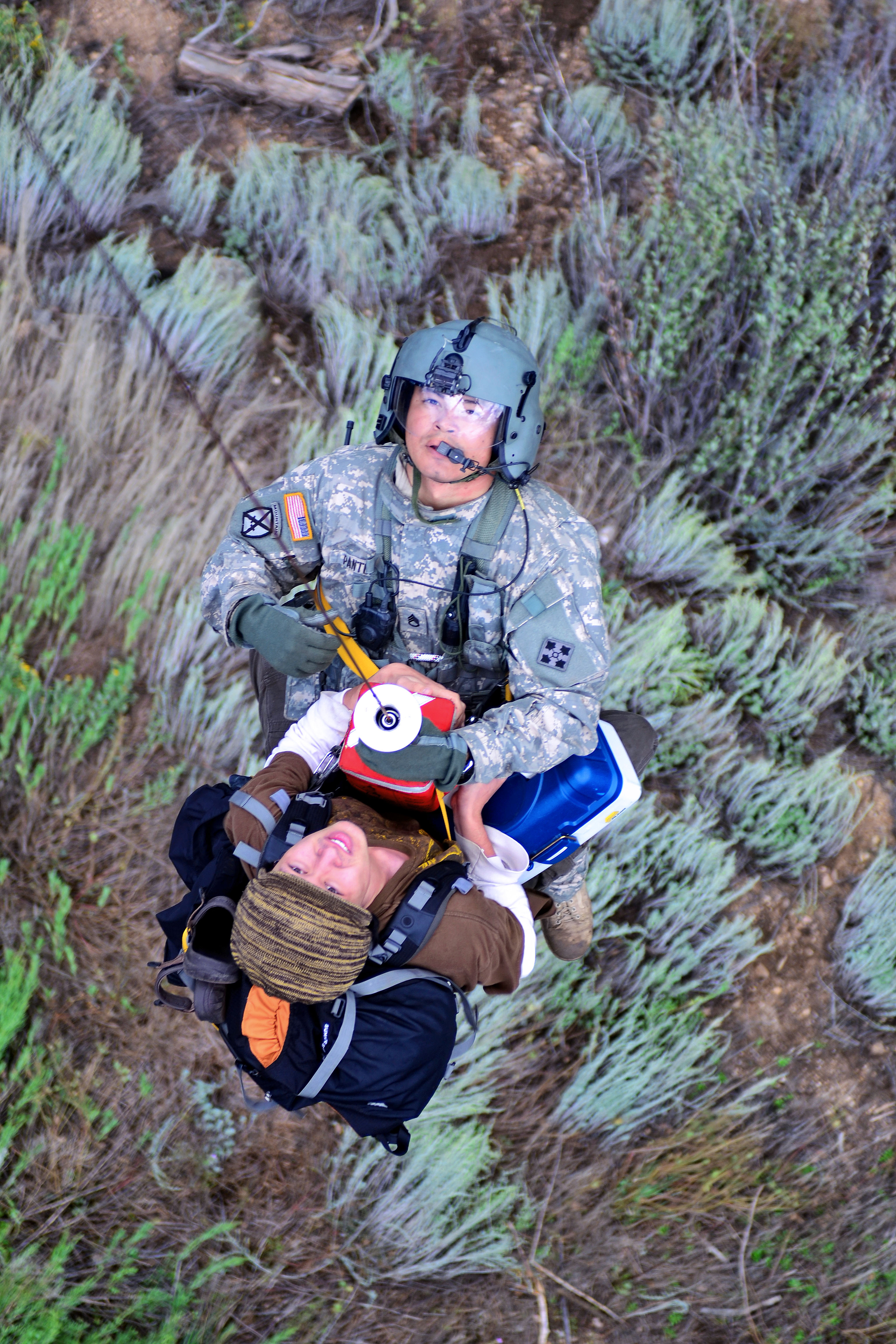 Army Staff Sgt. Jose Pantoja, left, carries an evacuee up a hoist onto ...