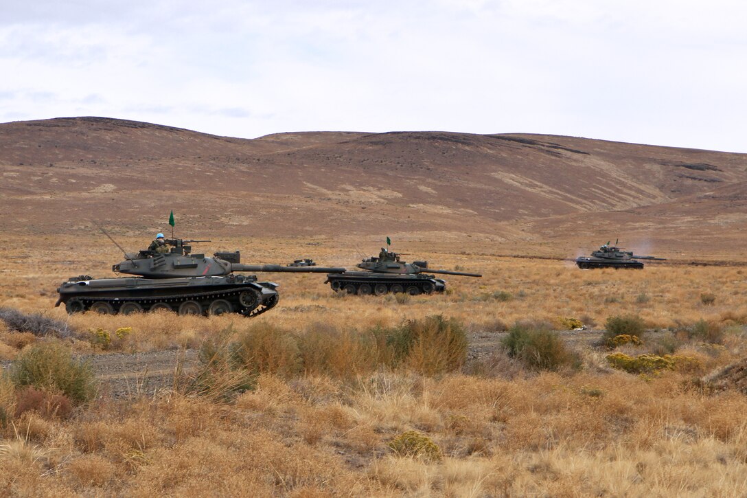 Japanese Ground Self-Defense Force tanks form a bounding overwatch line ...