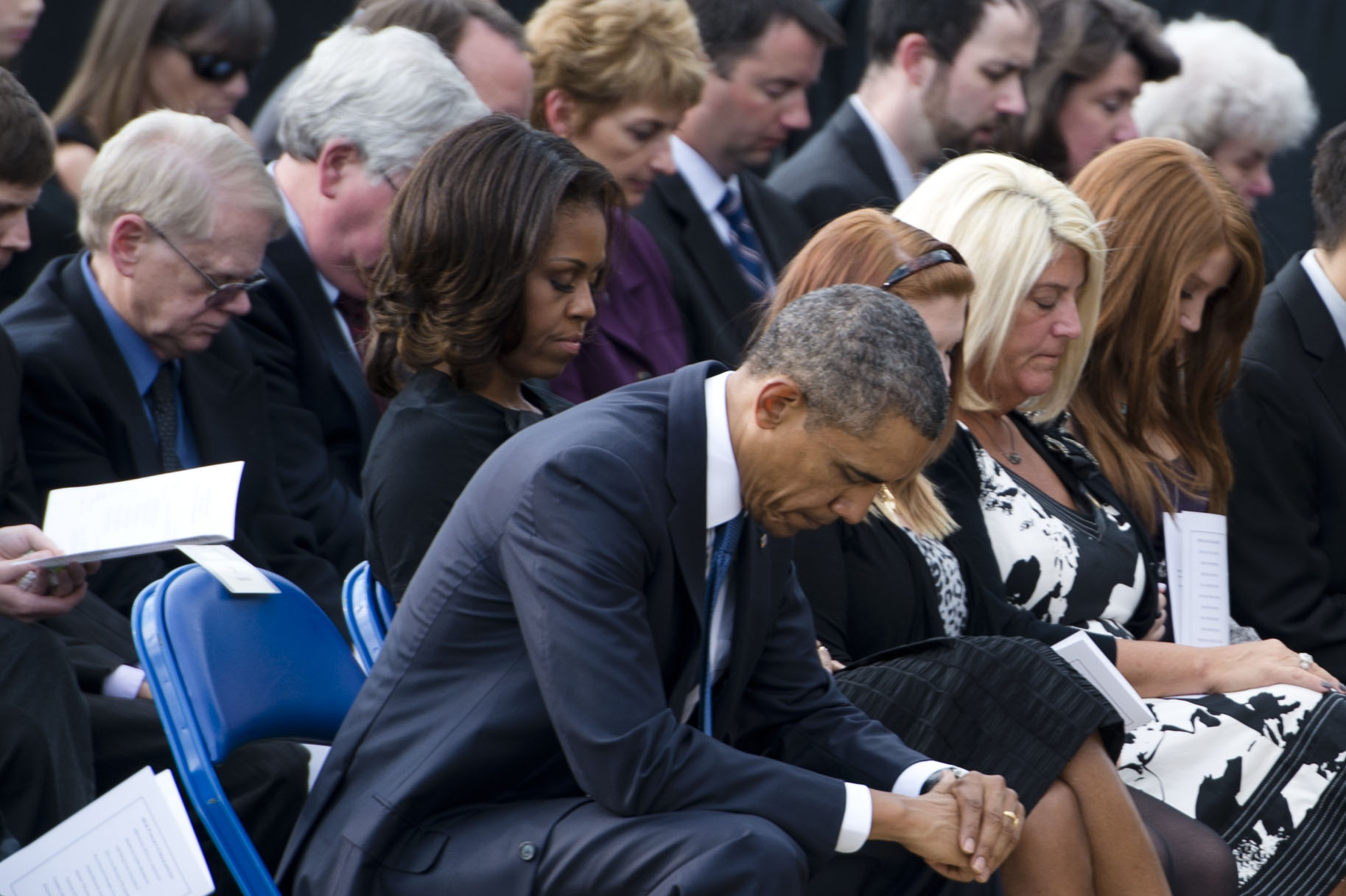 President Barack Obama and First Lady Michelle Obama bow their heads as ...