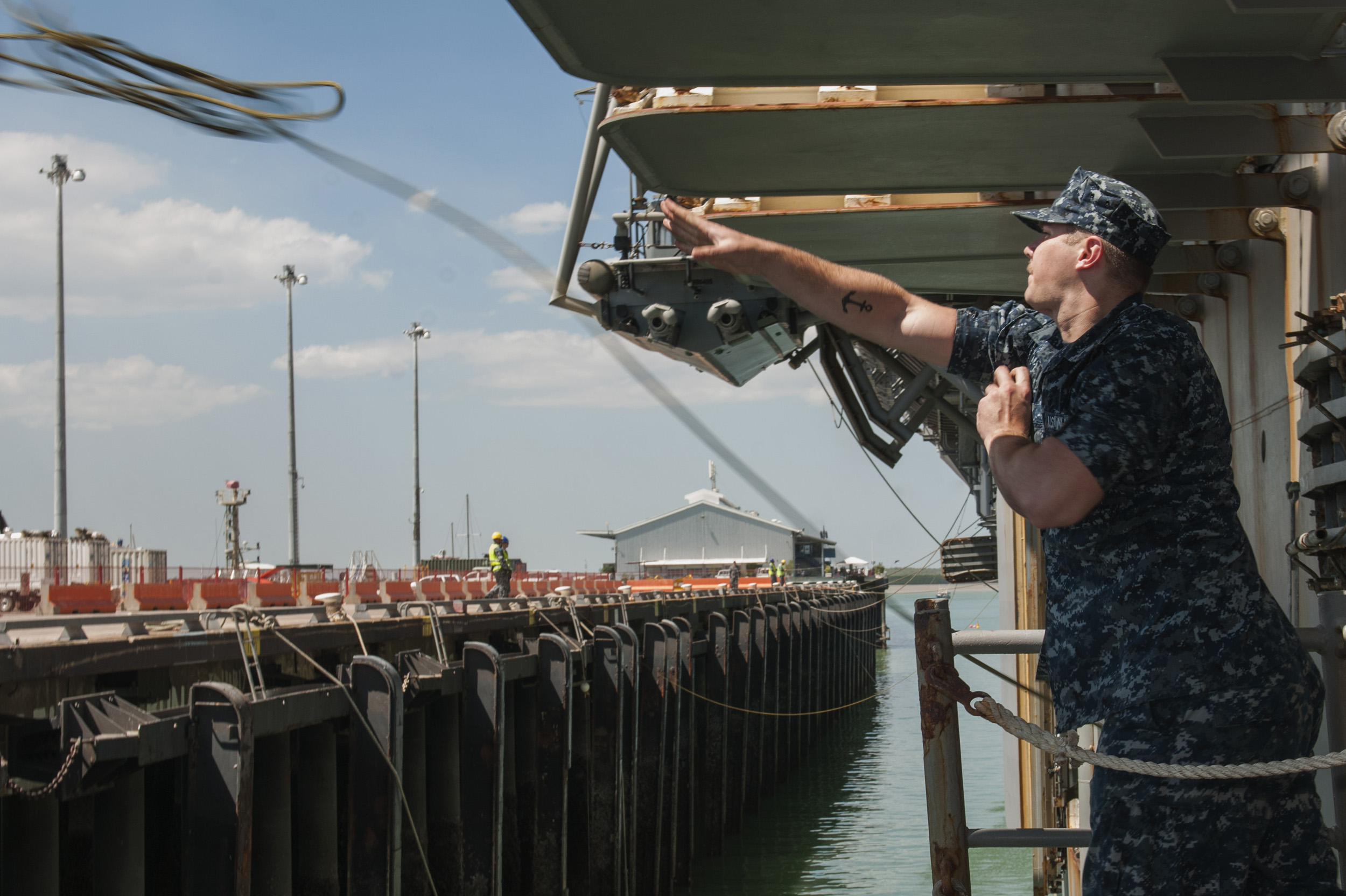 U.S. Navy Seaman Jeremiah Baker throws a messenger line from the USS ...