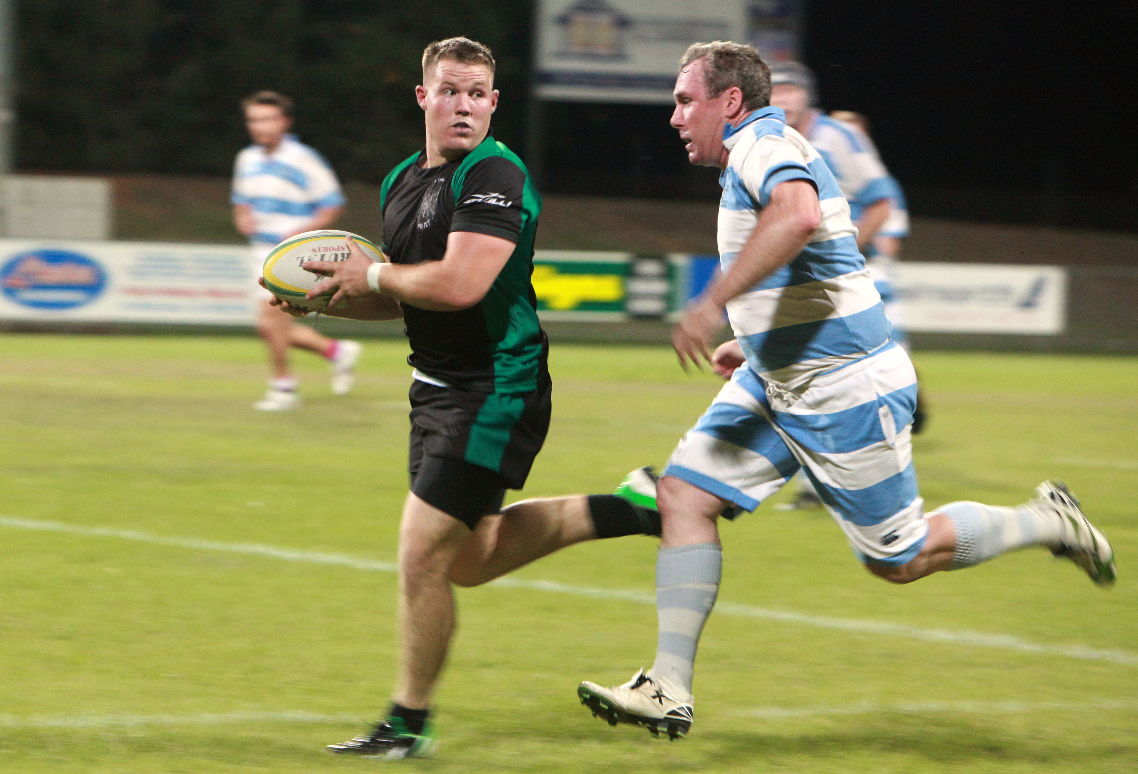 A Darwin rugby team player runs the ball down the field during the ...