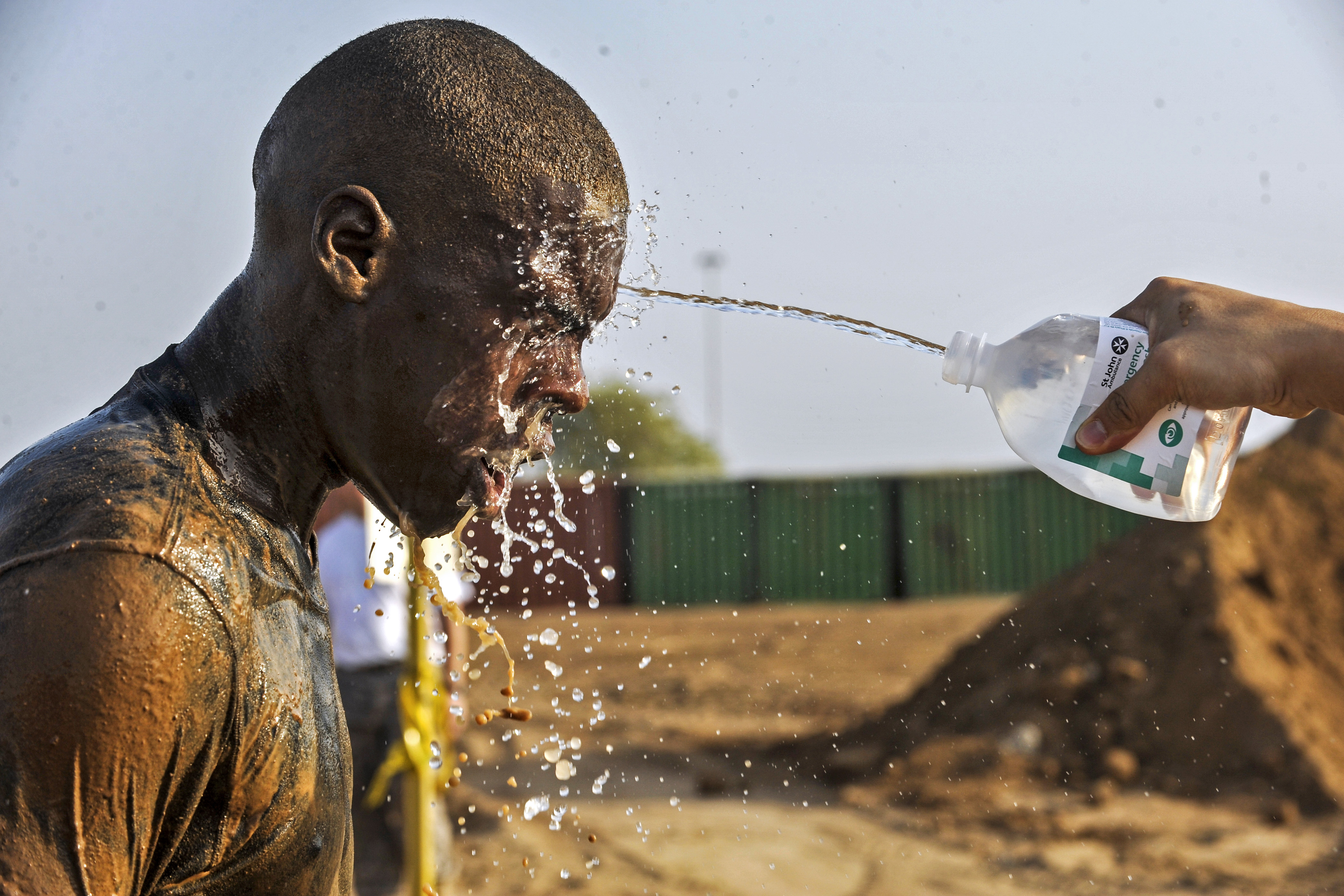 A U.S. service member has his eyes rinsed out after crawling through a ...