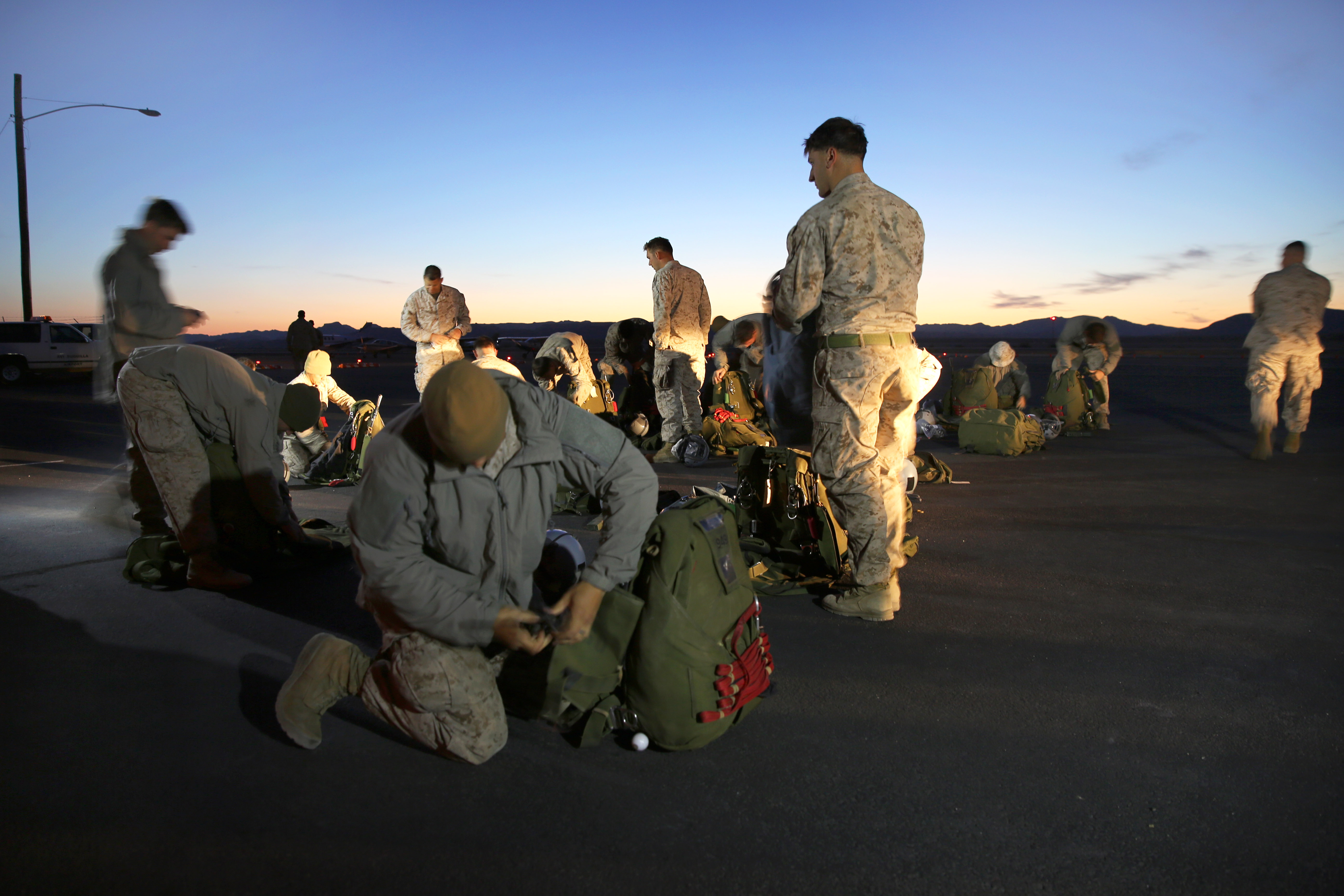 Marines prepare their parachutes before jumping out of a C-130 Hercules ...