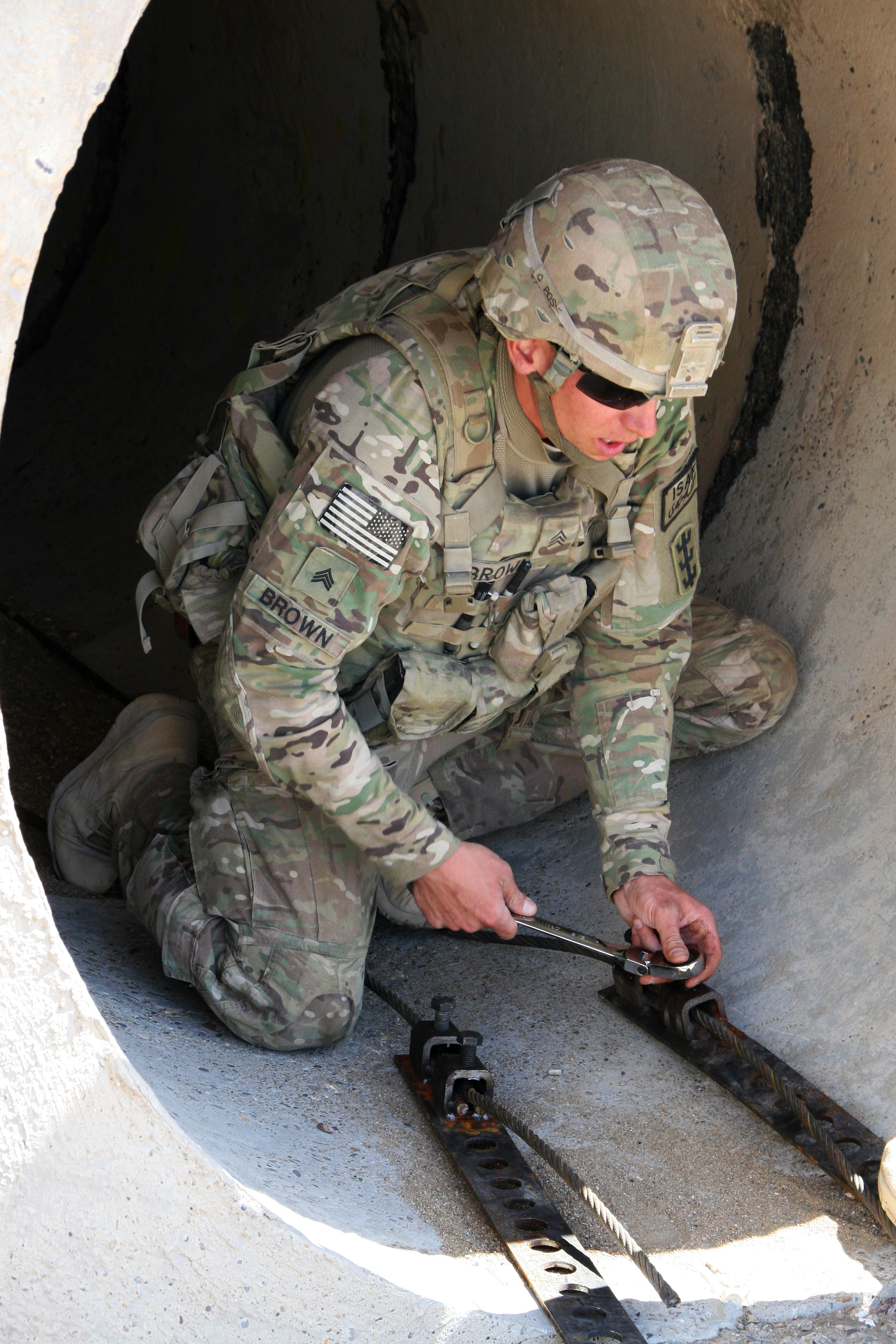 U.S. Army Sgt. Nathan Brown secures the tension force cables for the ...