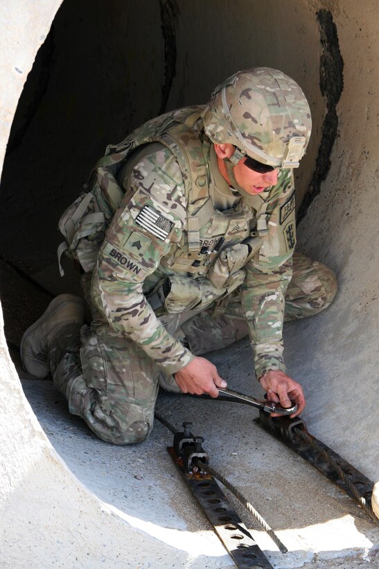 U.S. Army Sgt. Nathan Brown secures the tension force cables for the ...