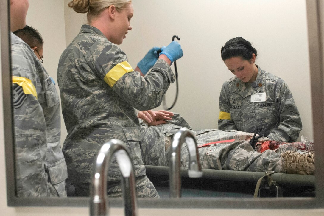 Air Force Maj. (Dr.) April Arseneau, right, performs emergency patient ...