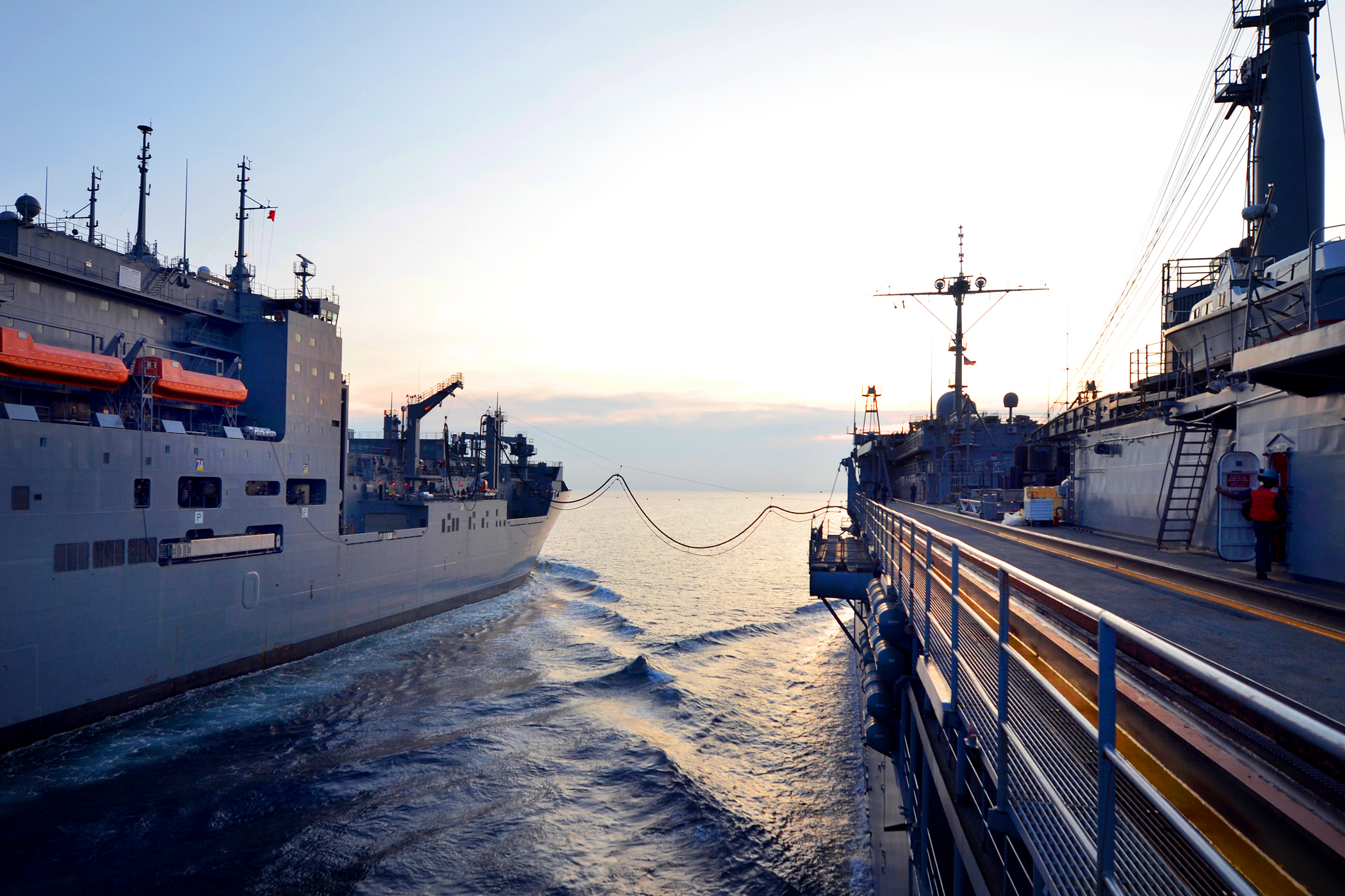 The submarine tender USS Frank Cable, right, conducts a replenishment ...