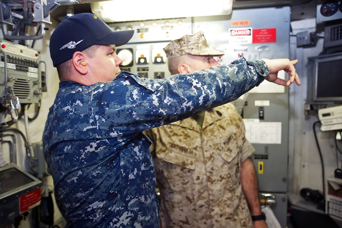 Navy Chief Petty Officer 3rd Class Arnold, foreground, explains to ...