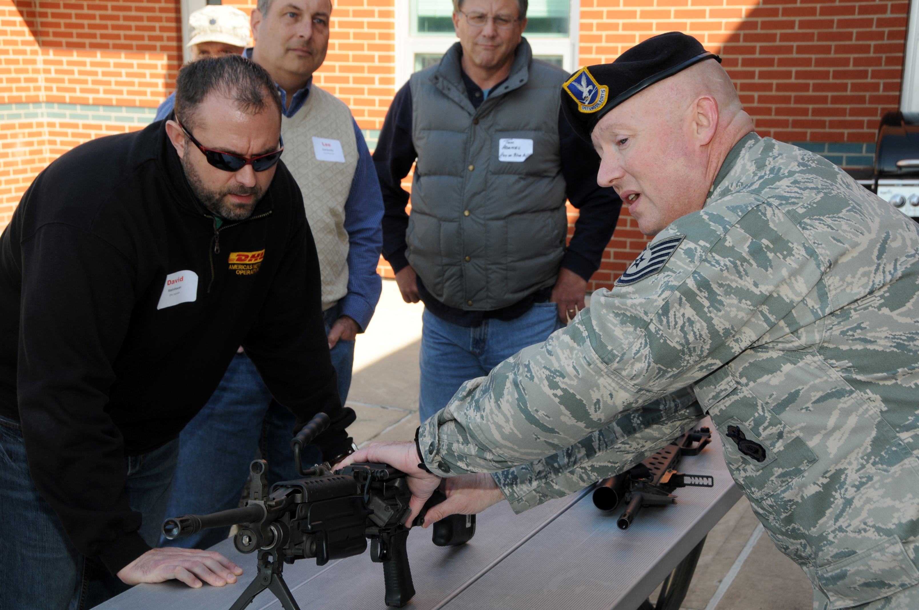 Security forces member explains rifle operation to employer