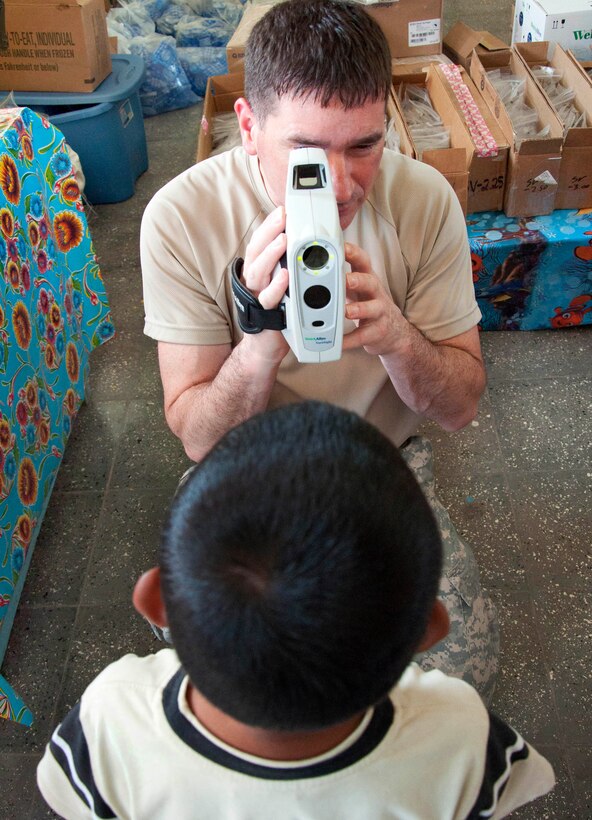 U.S. Army Master Sgt. Michael Stewart checks a Belizean boy's eyes in ...