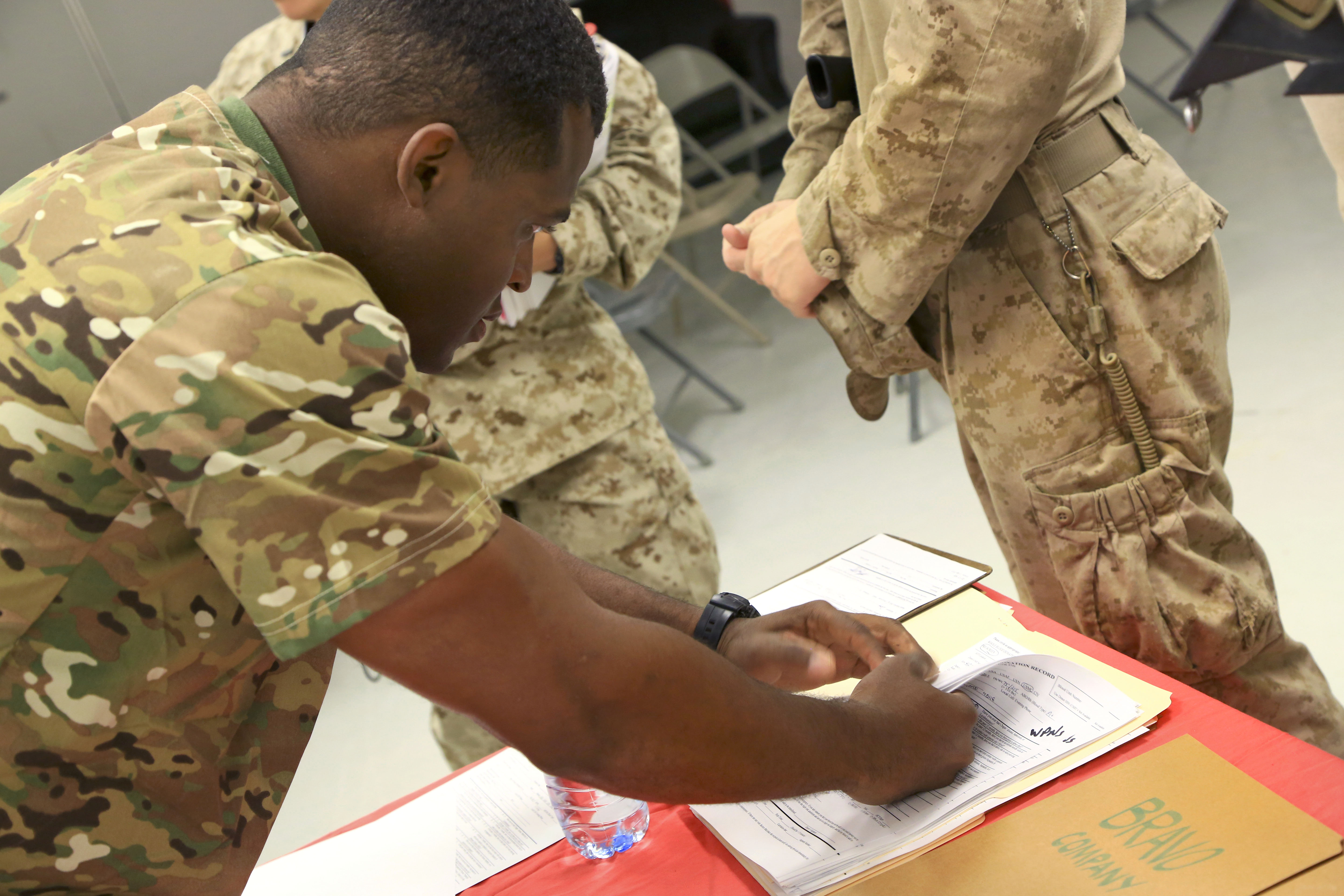 U.S. Navy Petty Officer 2nd Class Kowalsky Lucien assits a U.S. Marine ...