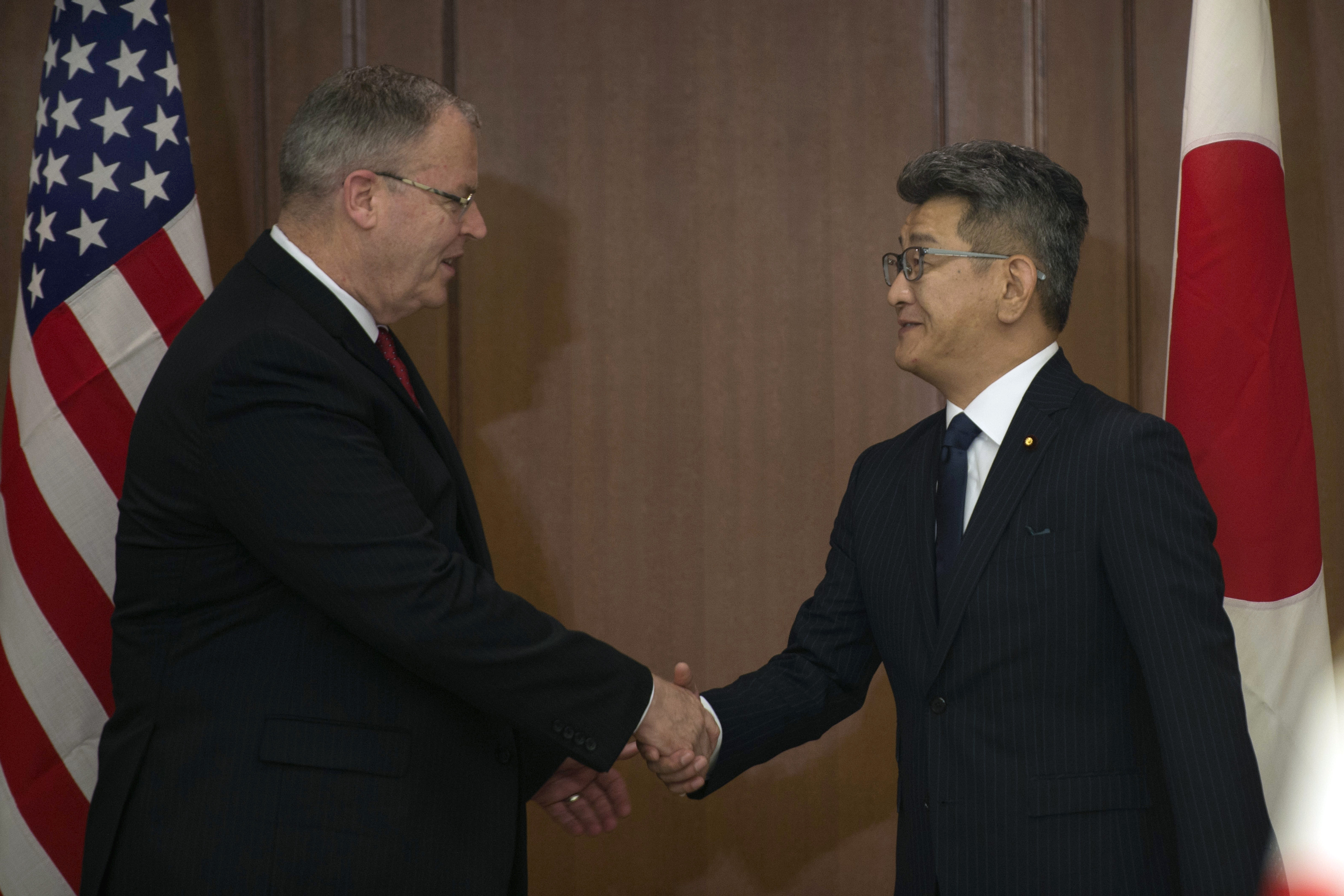 U.S. Deputy Defense Secretary Bob Work, left, shakes hands with Japanese Senior Vice Defense ...