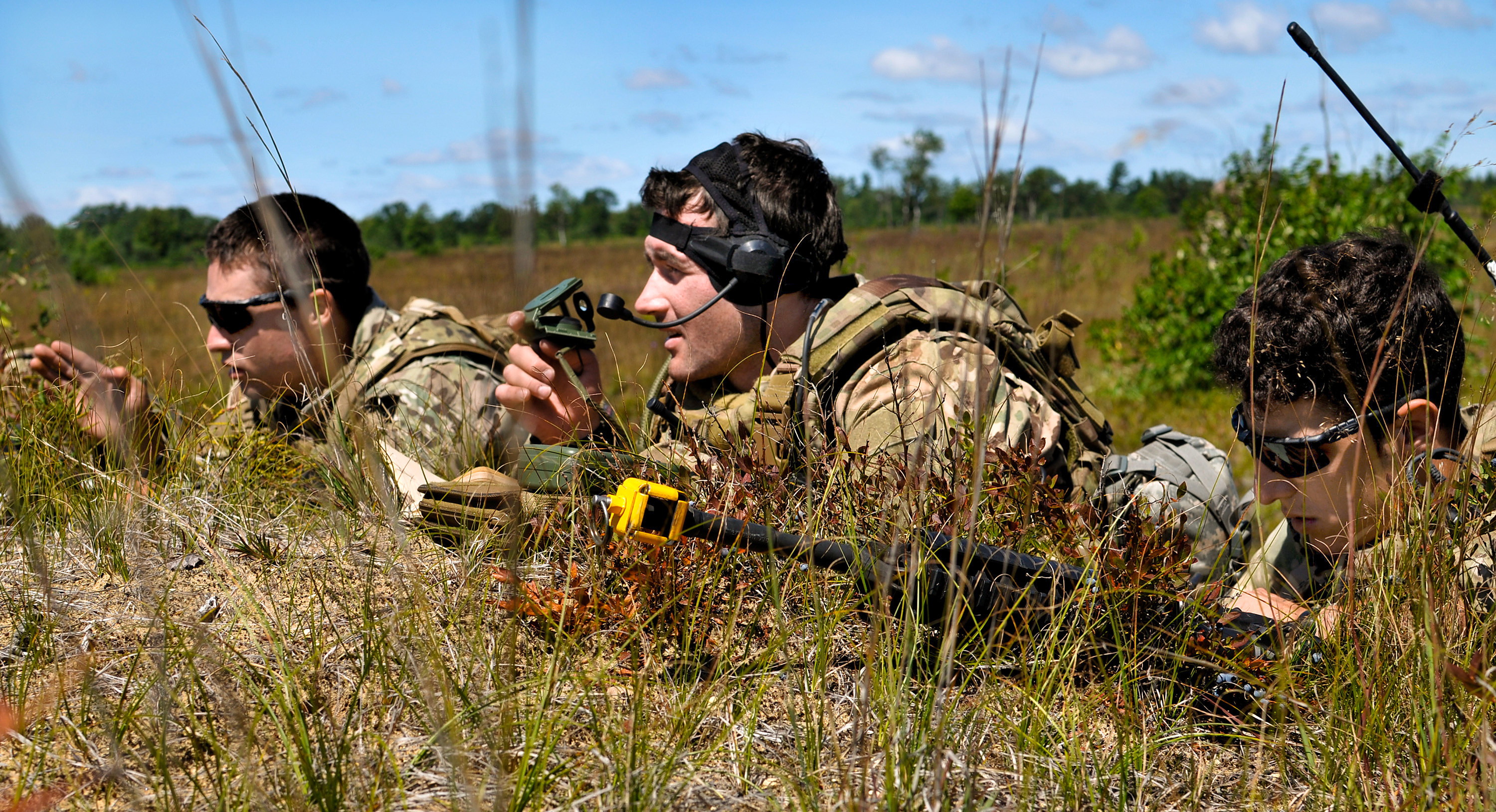 U.S. Air Force Senior Airman Ryan S. Godar, center, uses his compass to ...