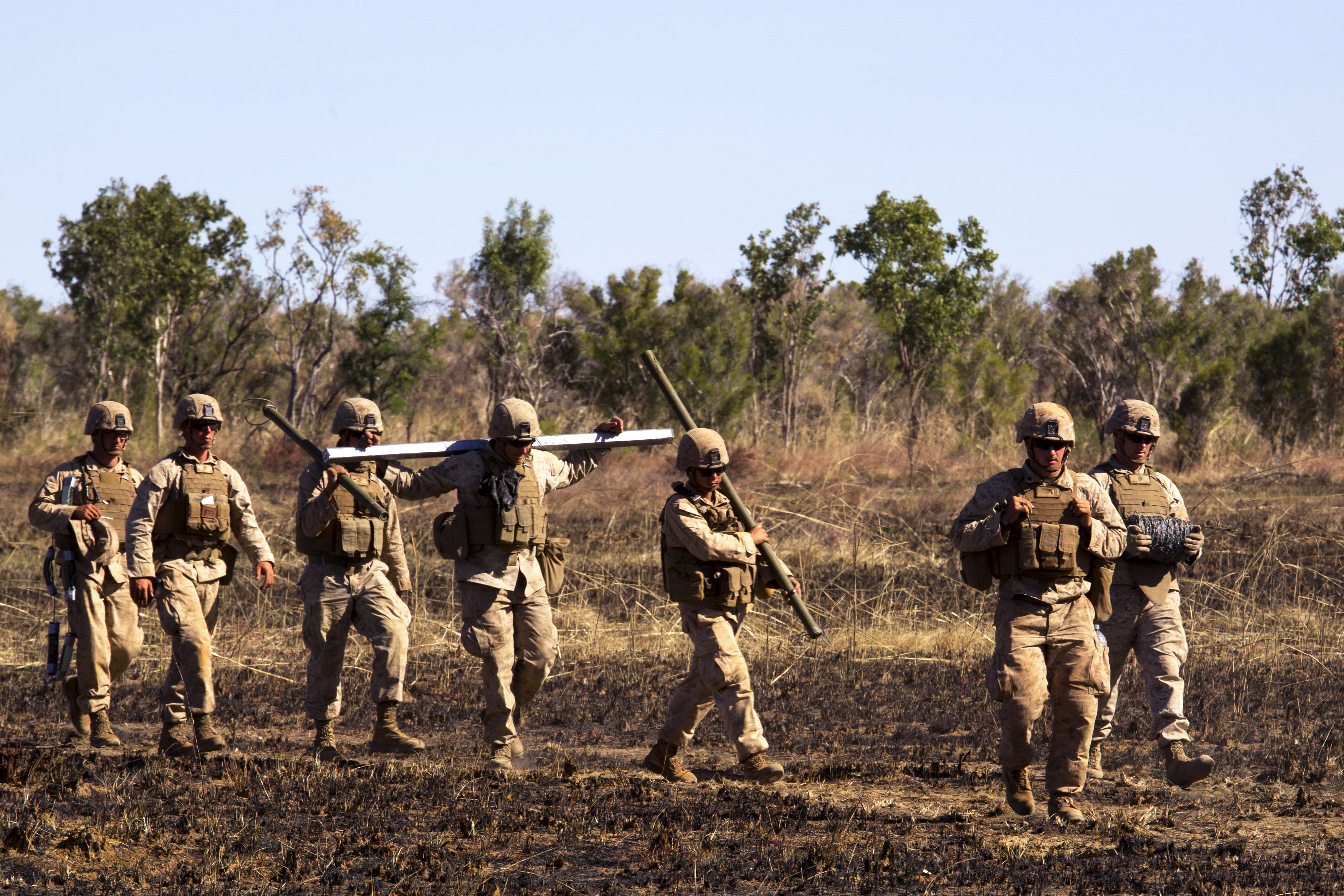 U.S. Marines walk downrange carrying improvised Bangalore torpedo and ...