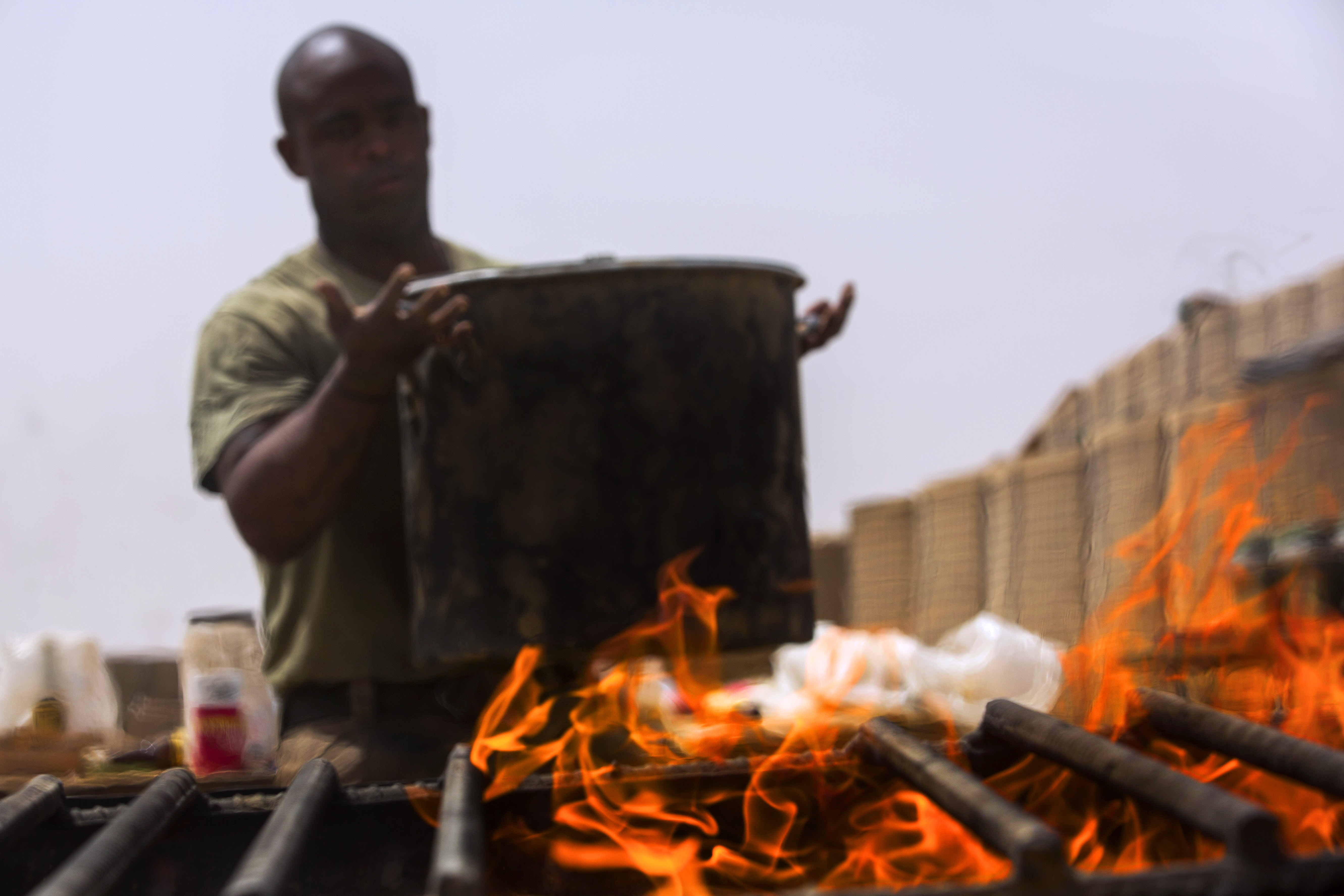 U.S. Marine Sgt. Omar Forrester puts a pot of rice on the grill during ...