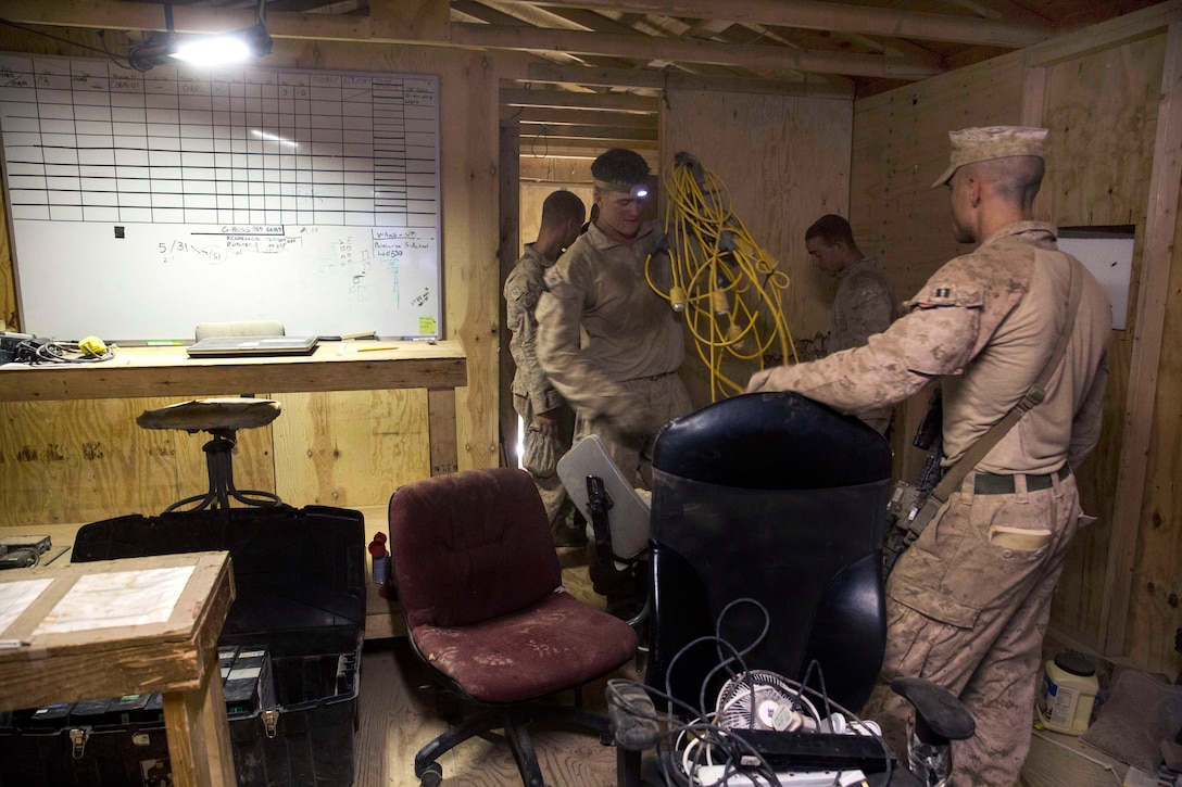 U.S. Marine Captain Jarred Reddinger, left, supervises Marines as they ...