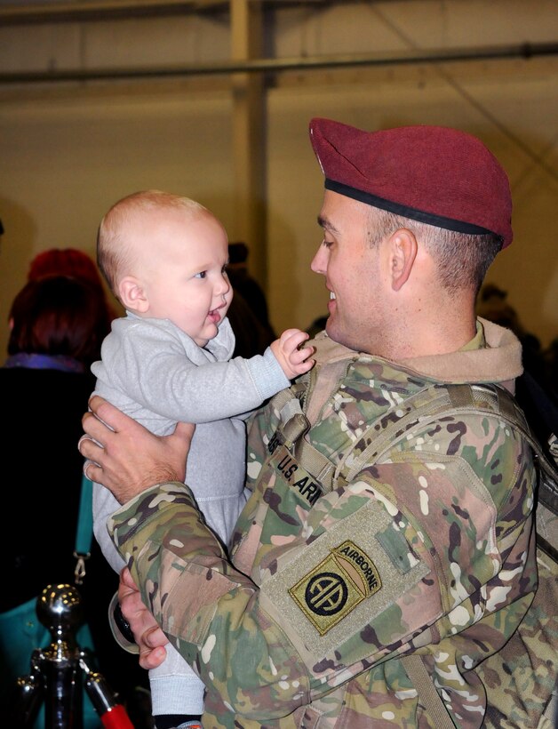 Army Chief Warrant Officer 2 Ryan Basso embraces his six-month old son ...