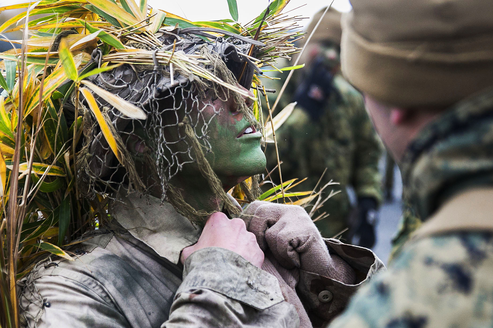 U.S. Marine Corps Lance Cpl. Jonas G. Dewald dons a ghillie suit on the ...