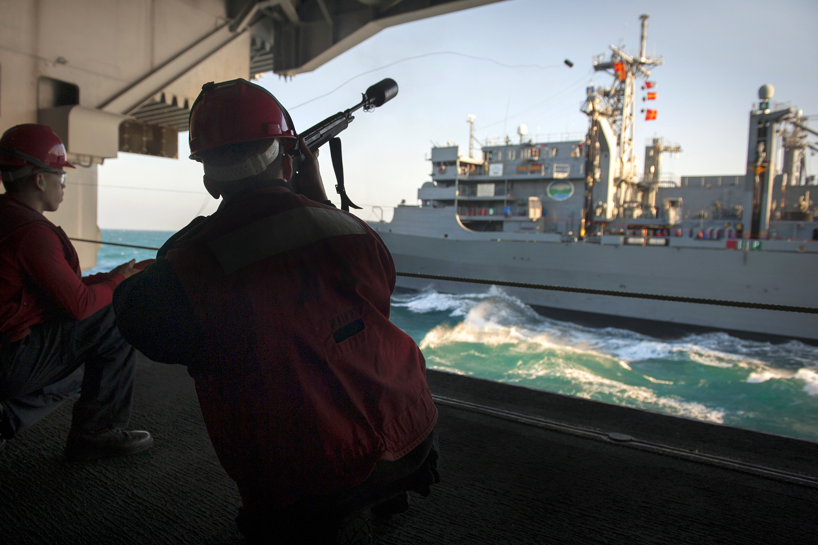 U.S. Navy Seaman Robert Cruz, a gunner's mate, fires a shot line from ...