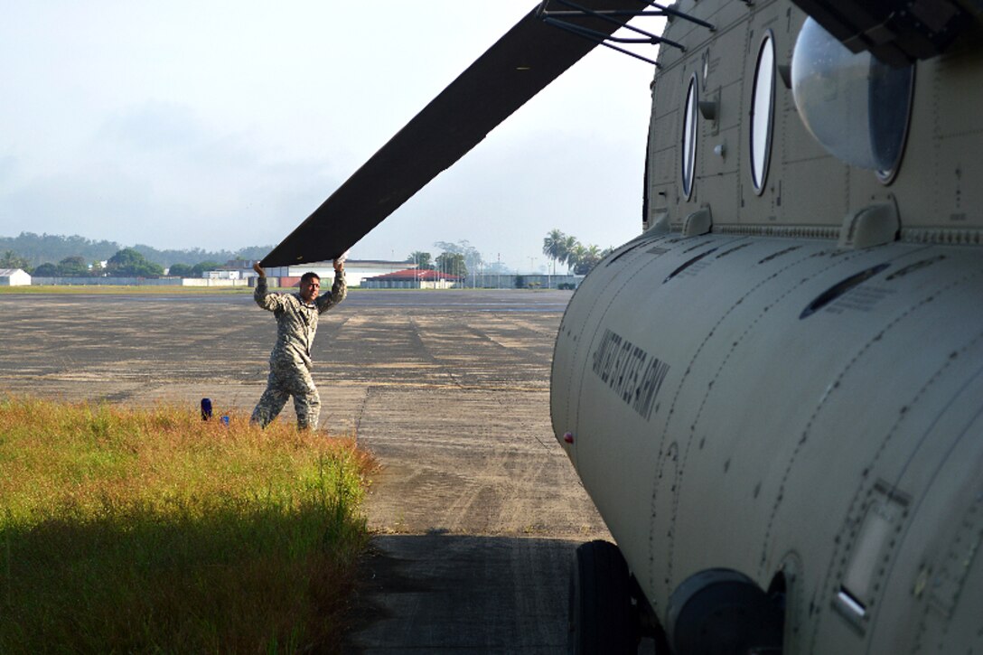 U.S. Army Spc. Brian Proenneke conducts preflight checks on a CH-47 ...