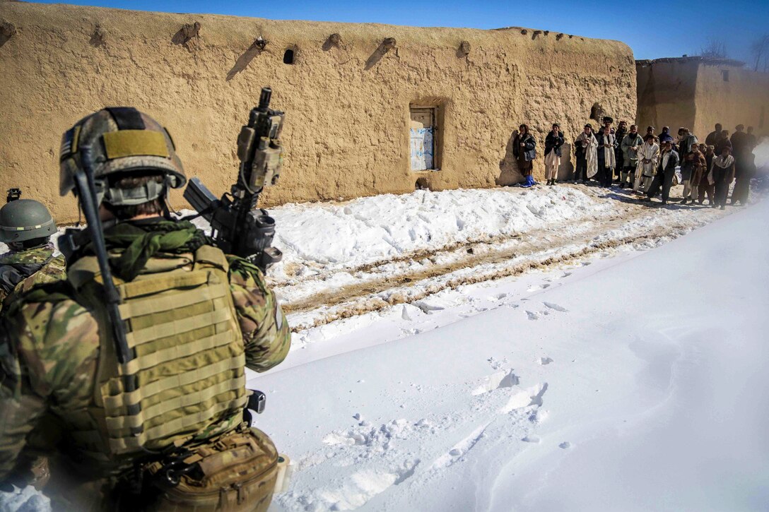 Afghan villagers watch as U.S. special forces soldiers and Afghan ...