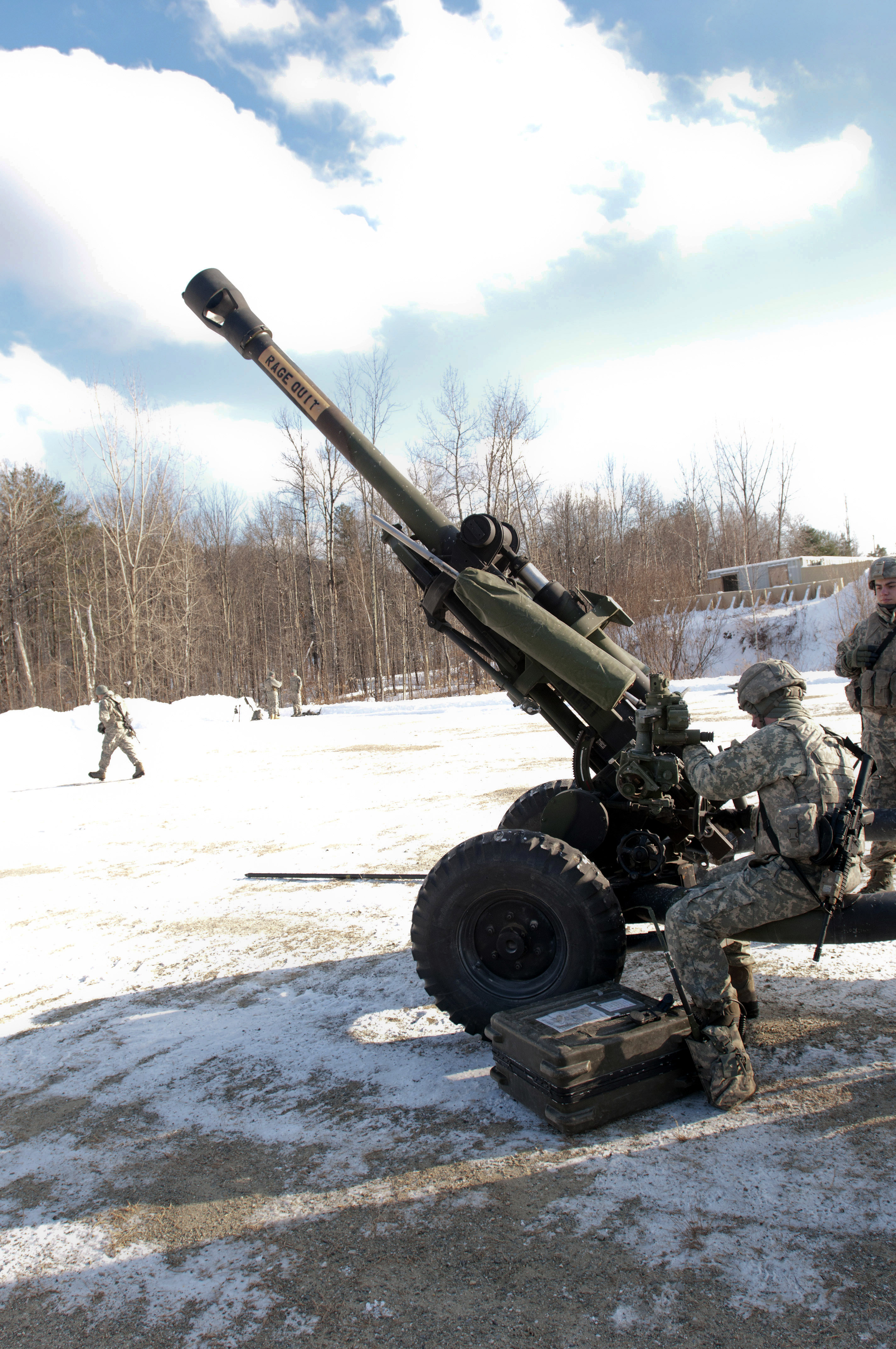 Army Sgt. Matthew Hunter lowers the cannon tube on an M119 howitzer ...