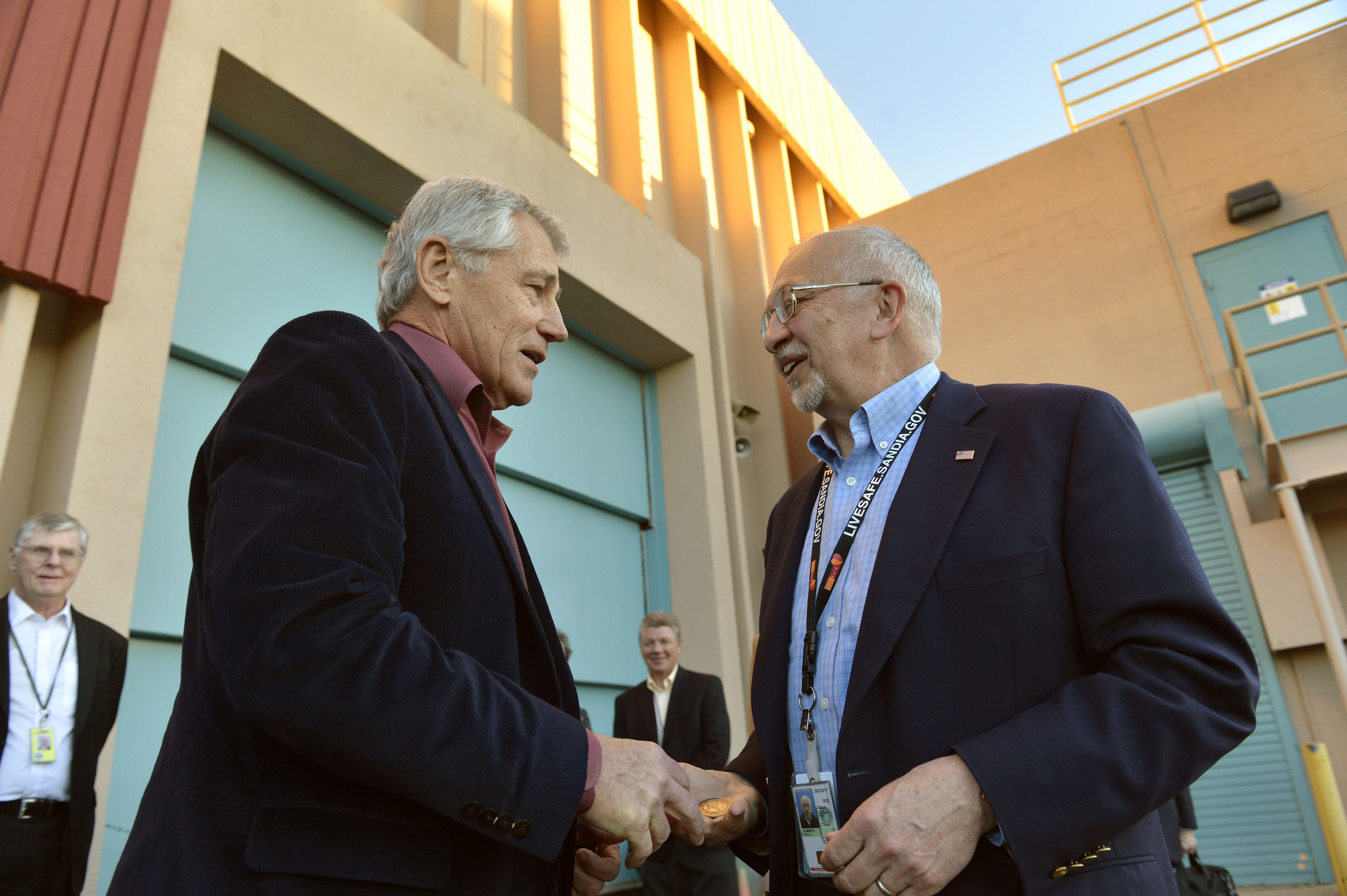 Defense Secretary Chuck Hagel, left, offers Paul Hommert, president and ...