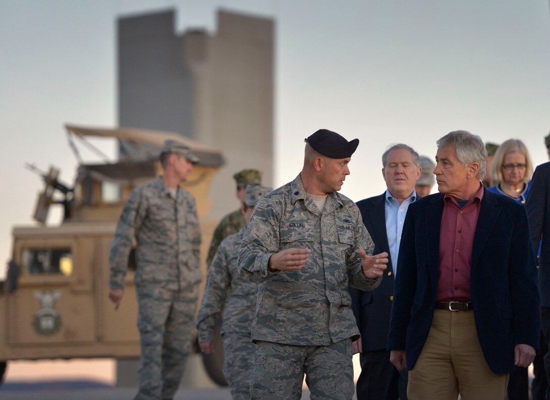 Defense Secretary Chuck Hagel, right, receives an escort into a bunker ...