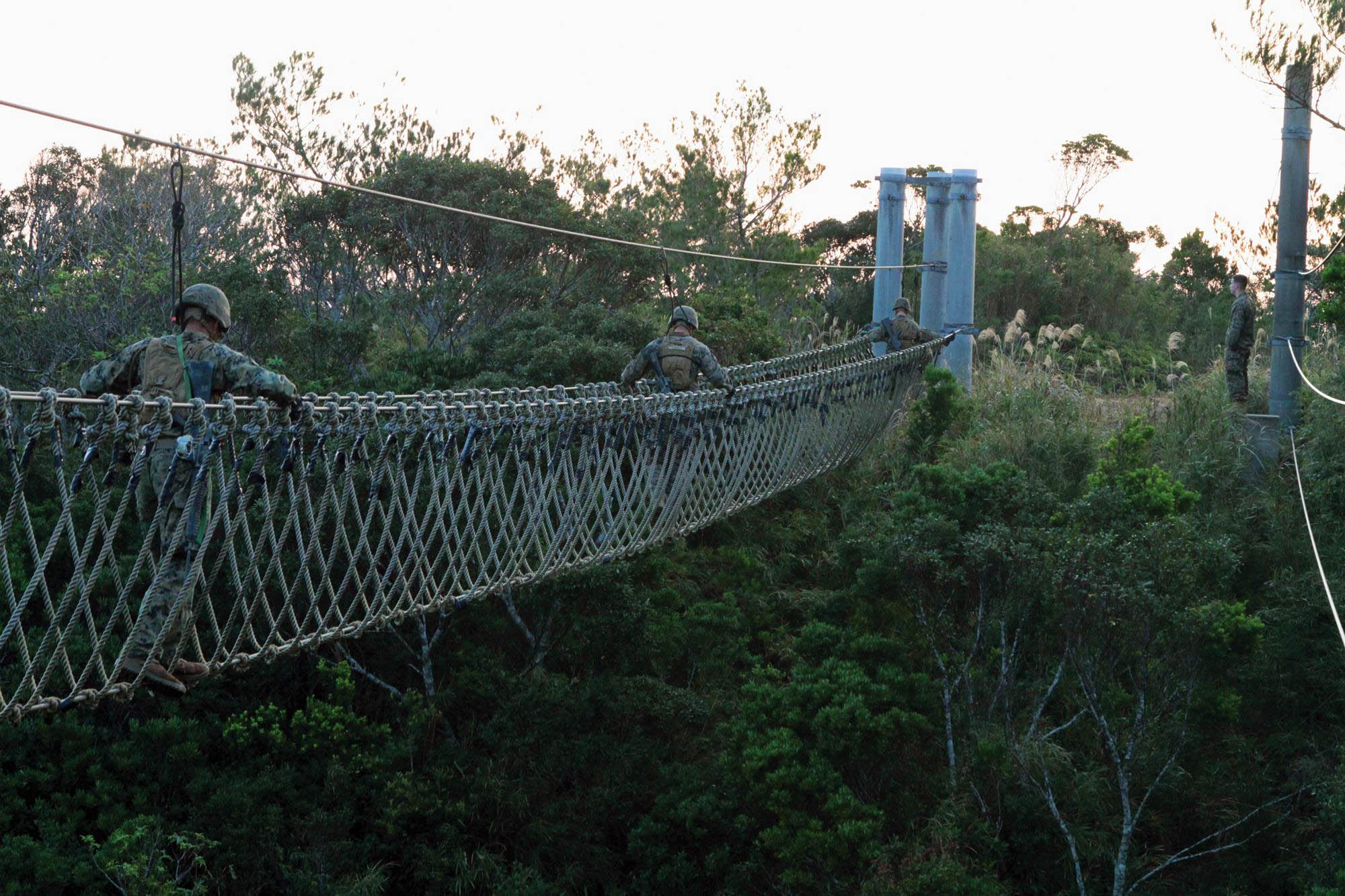 U.S. Marines cross a rope bridge at the end of an endurance course at ...