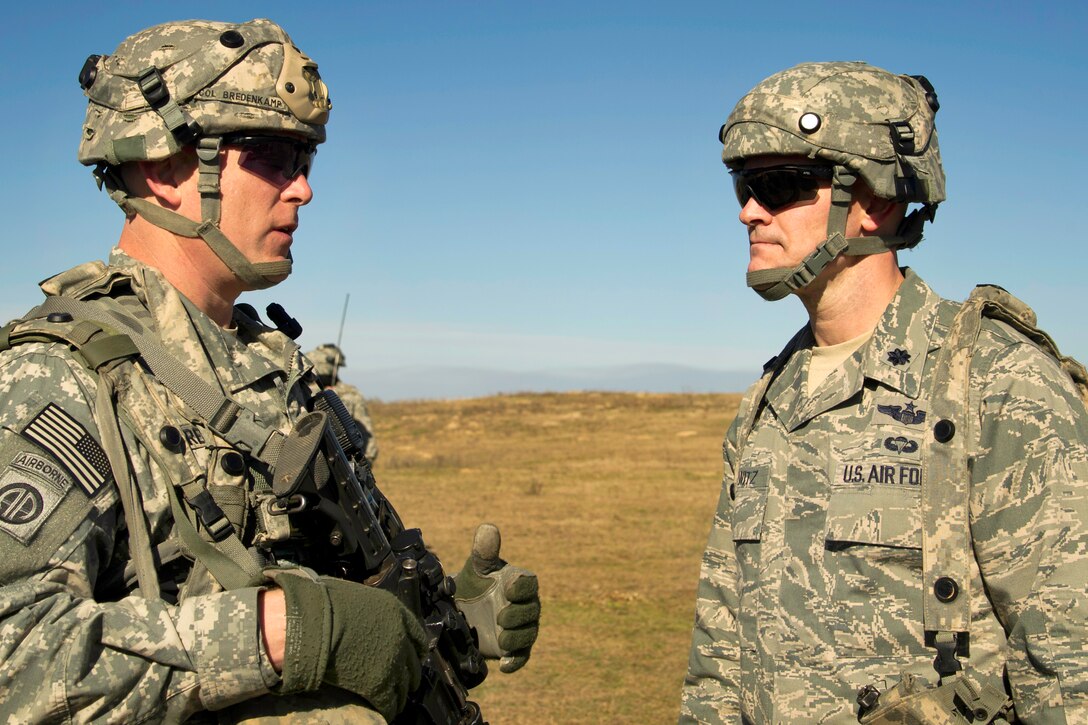 U.S. Army Col. Trevor Bredenkamp, left, speaks with Air Force Lt. Col ...