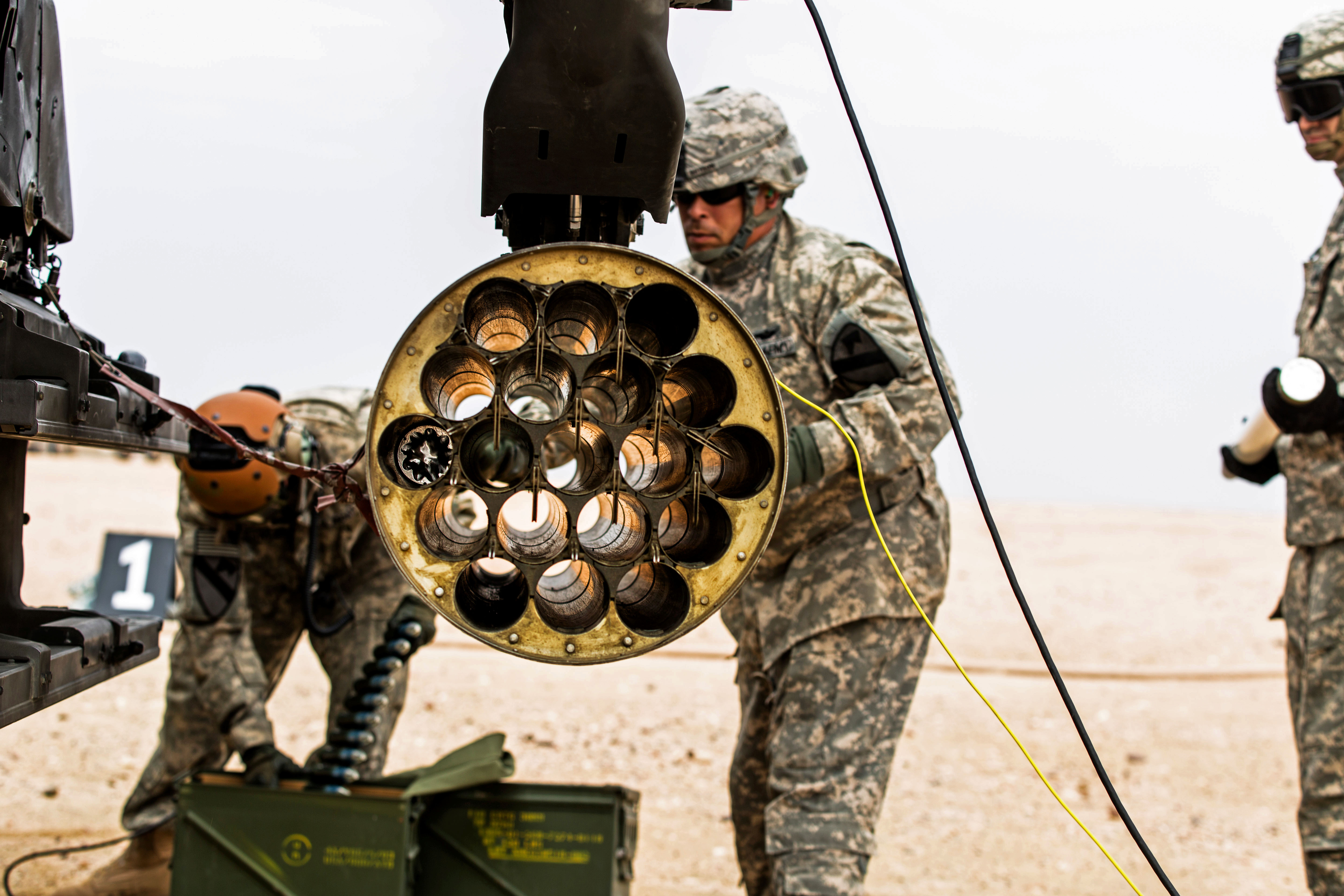 U.S. soldiers load an AH-64 Apache helicopter with rockets during a ...
