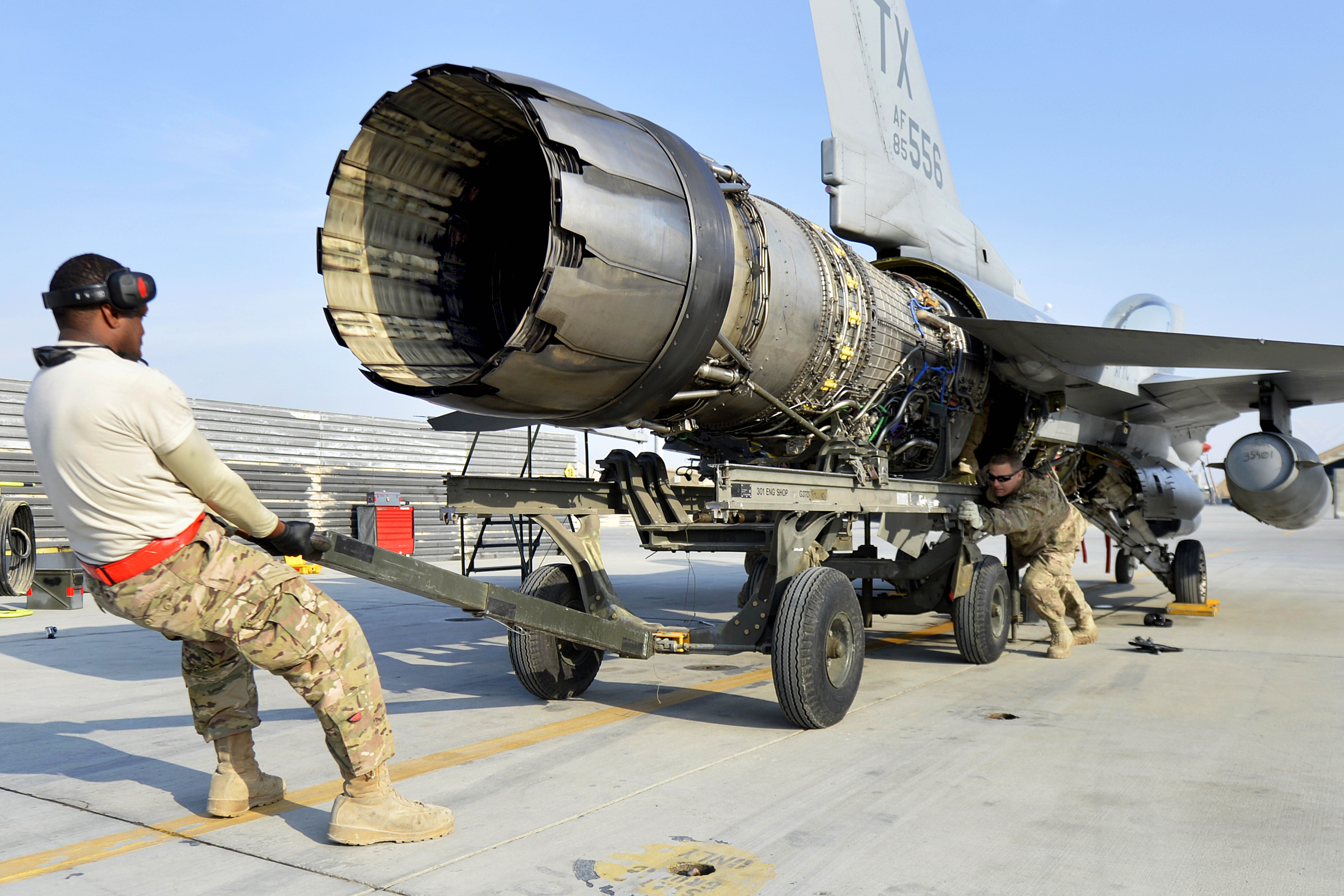 U.S. airmen work to remove the engine from an F-16 Fighting Falcon ...
