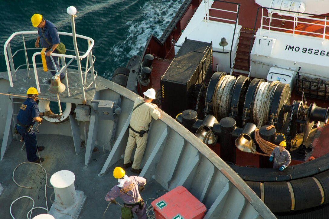 Line handlers aboard MV Cape Ray work with an Italian tugboat to moor ...