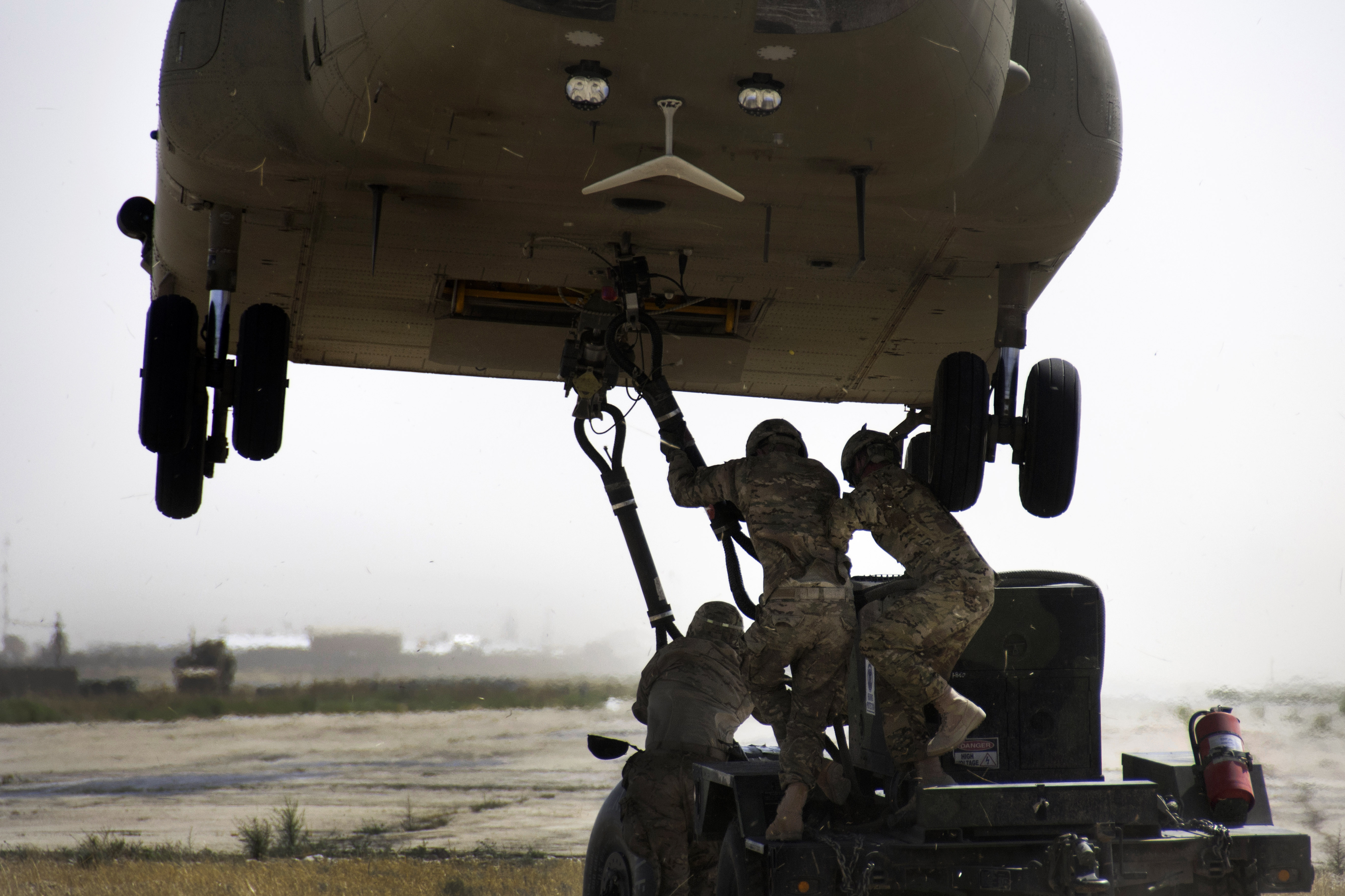 U.S. soldiers secure the cargo line to a CH-47 Chinook helicopter load ...