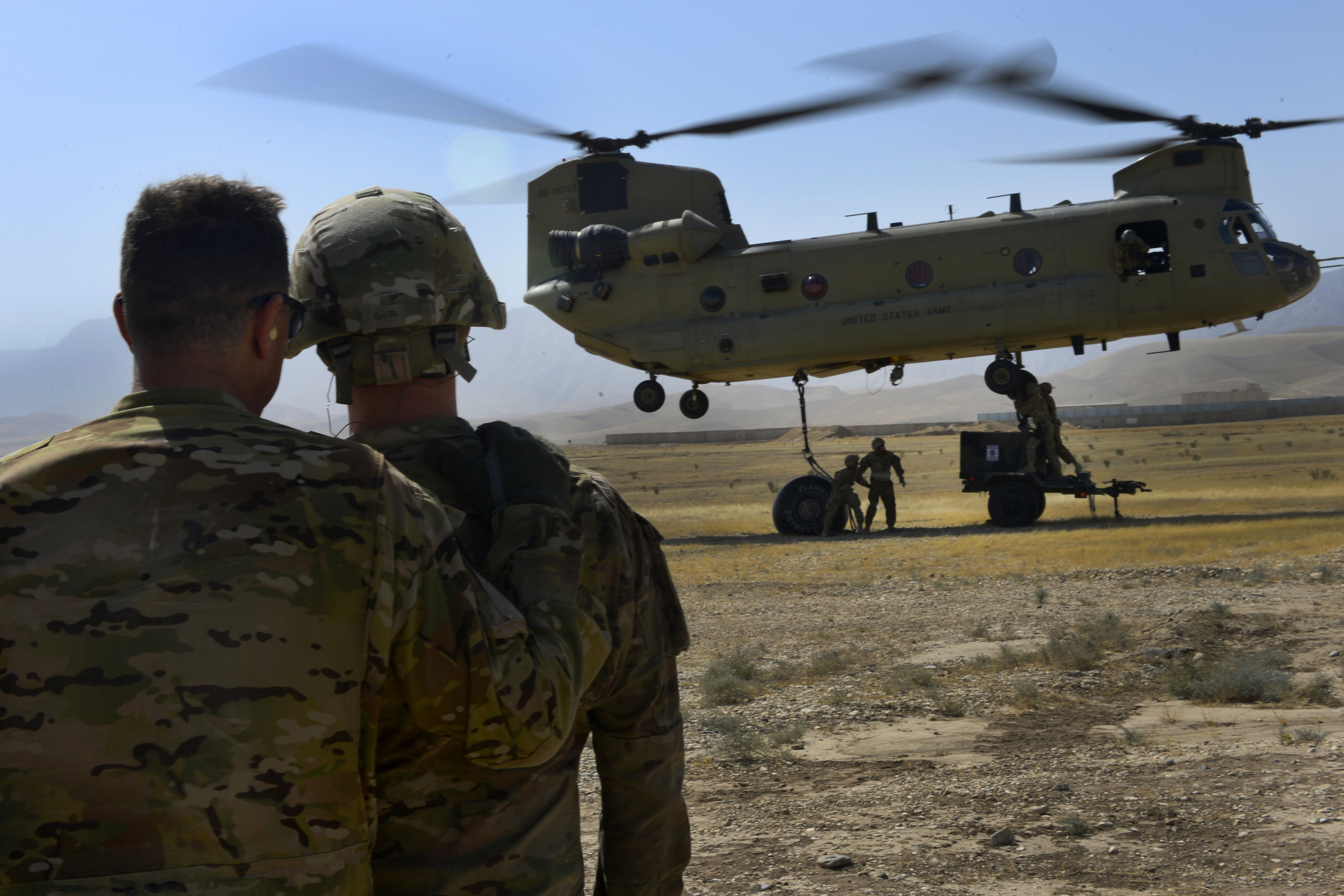 A U.S. Army instructor, left, tells a soldier on how to attach a ...