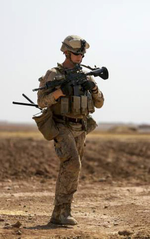 U.S. Marine Cpl. Brandon Jewell patrols through a field outside a ...