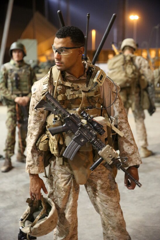 U.S. Marine Corps Cpl. Anthony Davis dons his personal protective gear ...