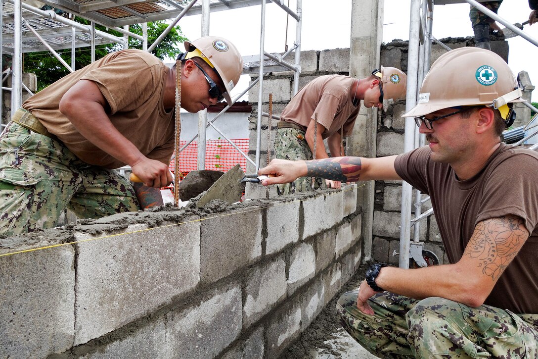 U.S. Navy Petty Officer 3rd Class Eduardo Ellorin, left, and U.S. Navy ...