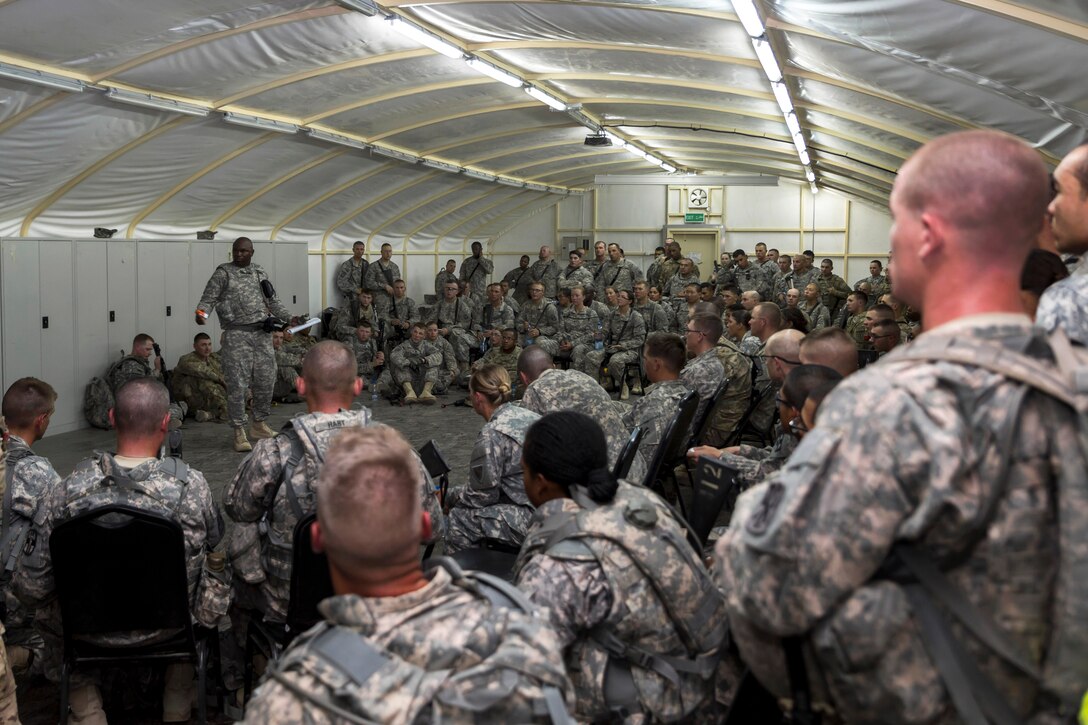 U.S. soldiers listen to a briefing before conducting their final ...