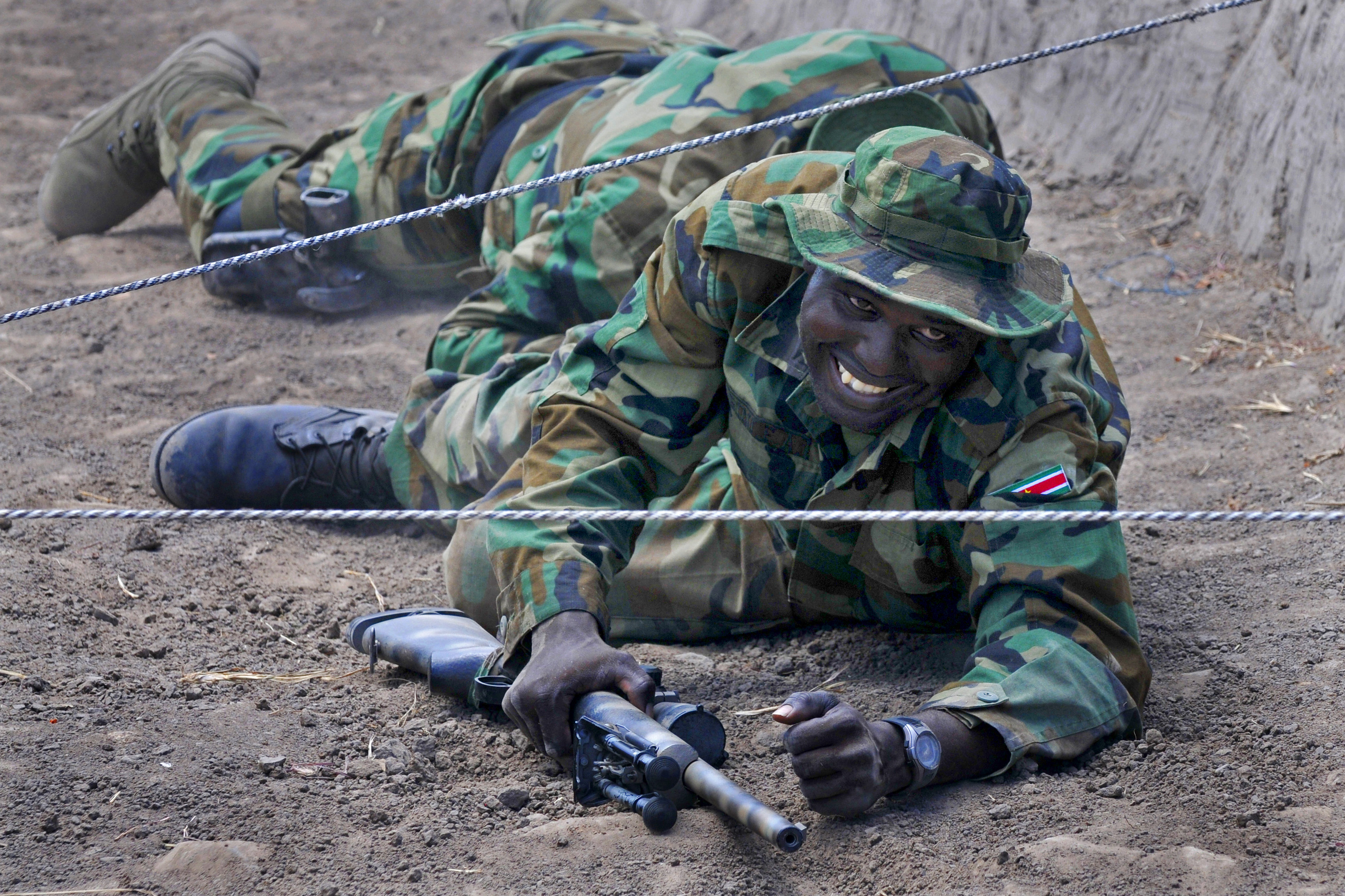 Members of Suriname's special operations team crawl under wires as part ...