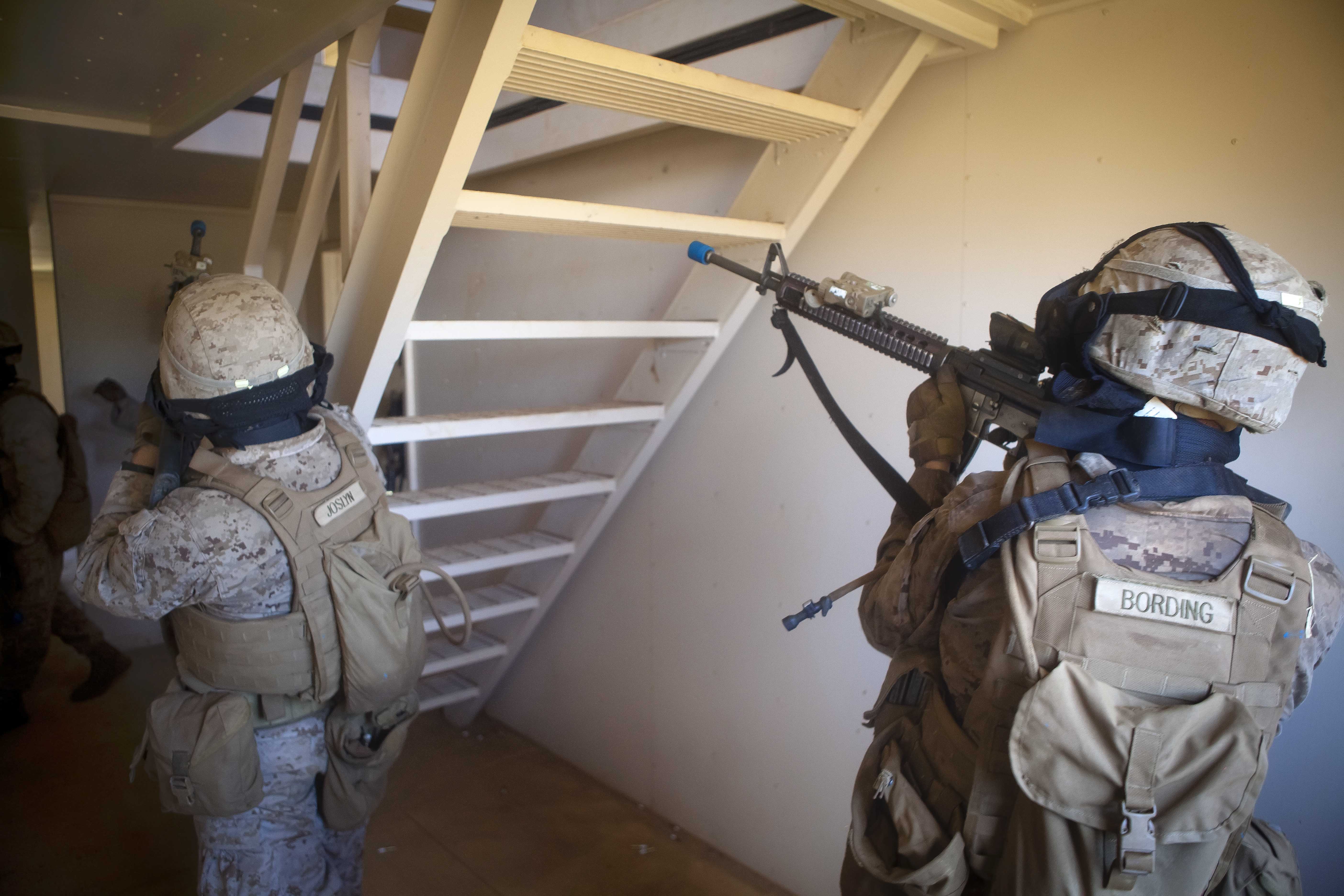 Marines provide security on a stairwell during a raid on a simulated ...