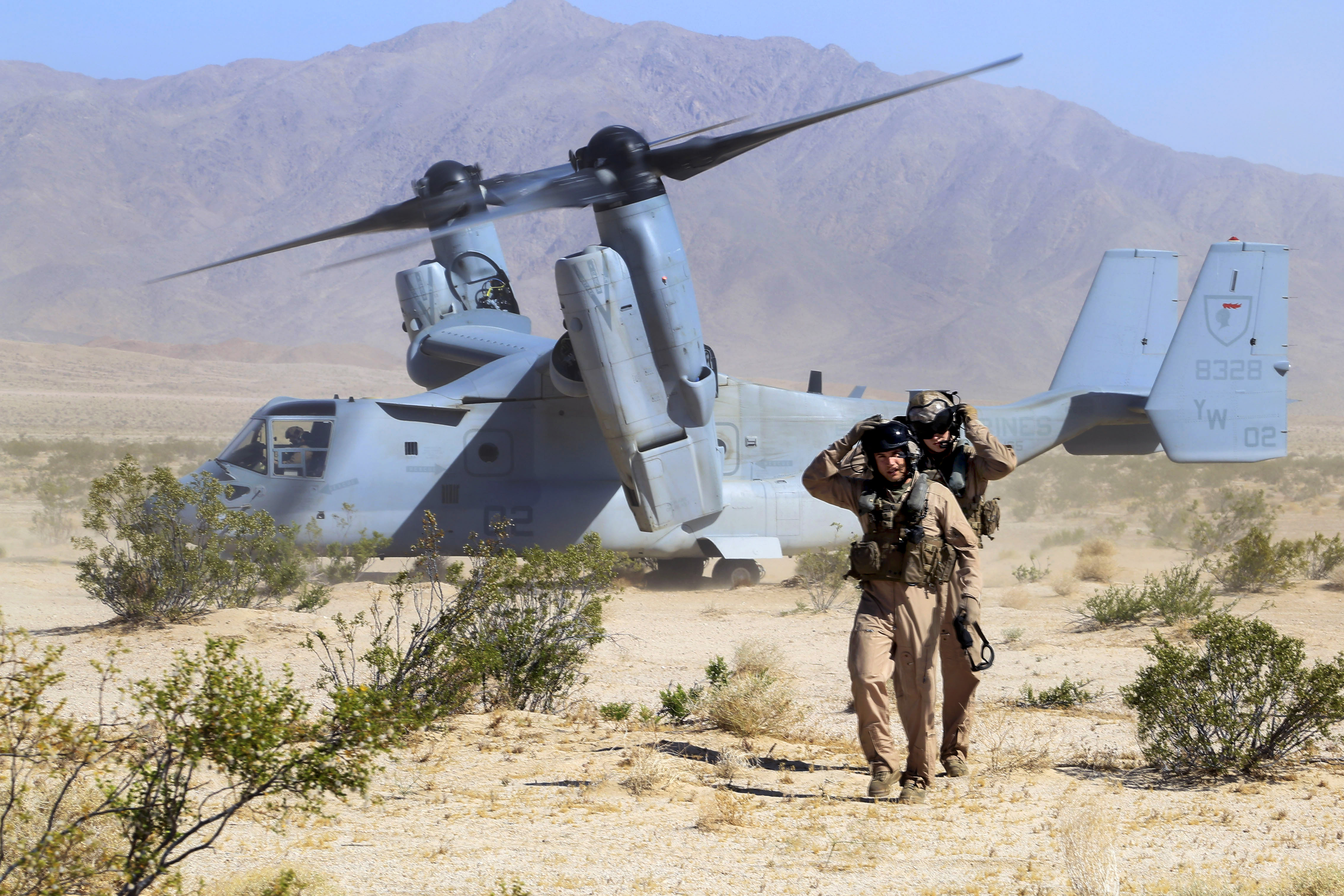 Marine Corps V-22 Osprey pilots and crew chiefs walk toward the ...