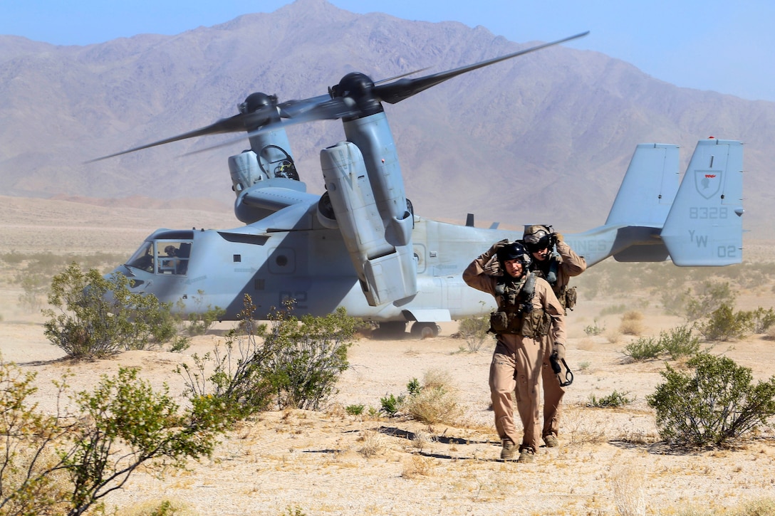 Marine Corps V-22 Osprey pilots and crew chiefs walk toward the ...