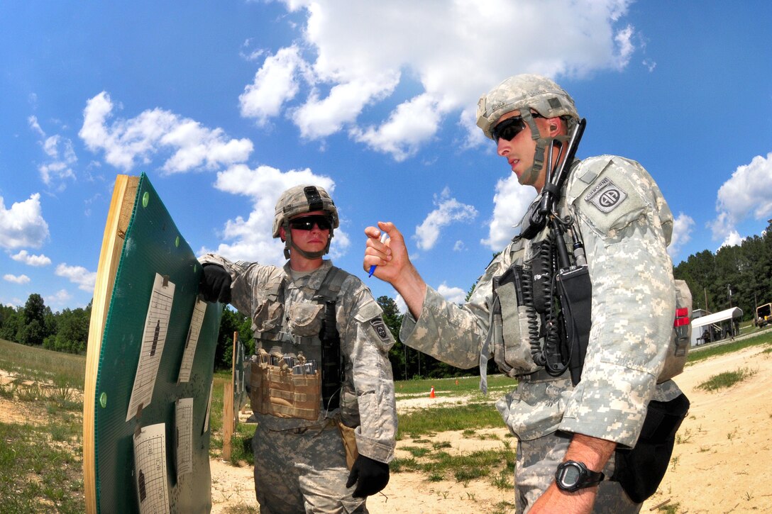 A paratrooper reviews his zeroing card before making any adjustments ...