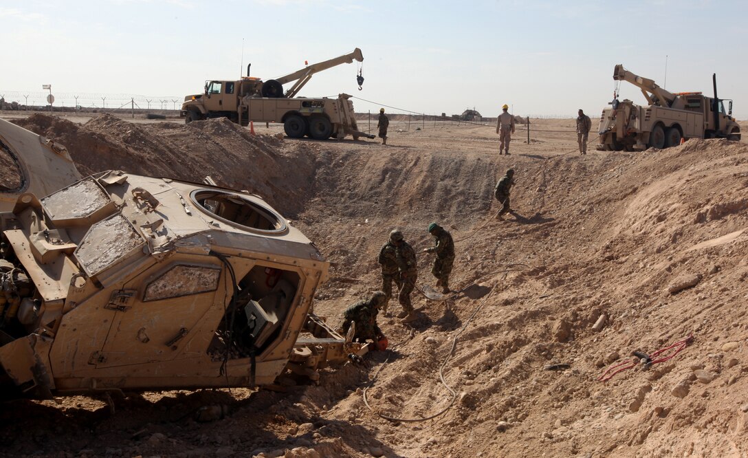 Afghan soldiers move quickly to properly attach cables from two wrecker ...
